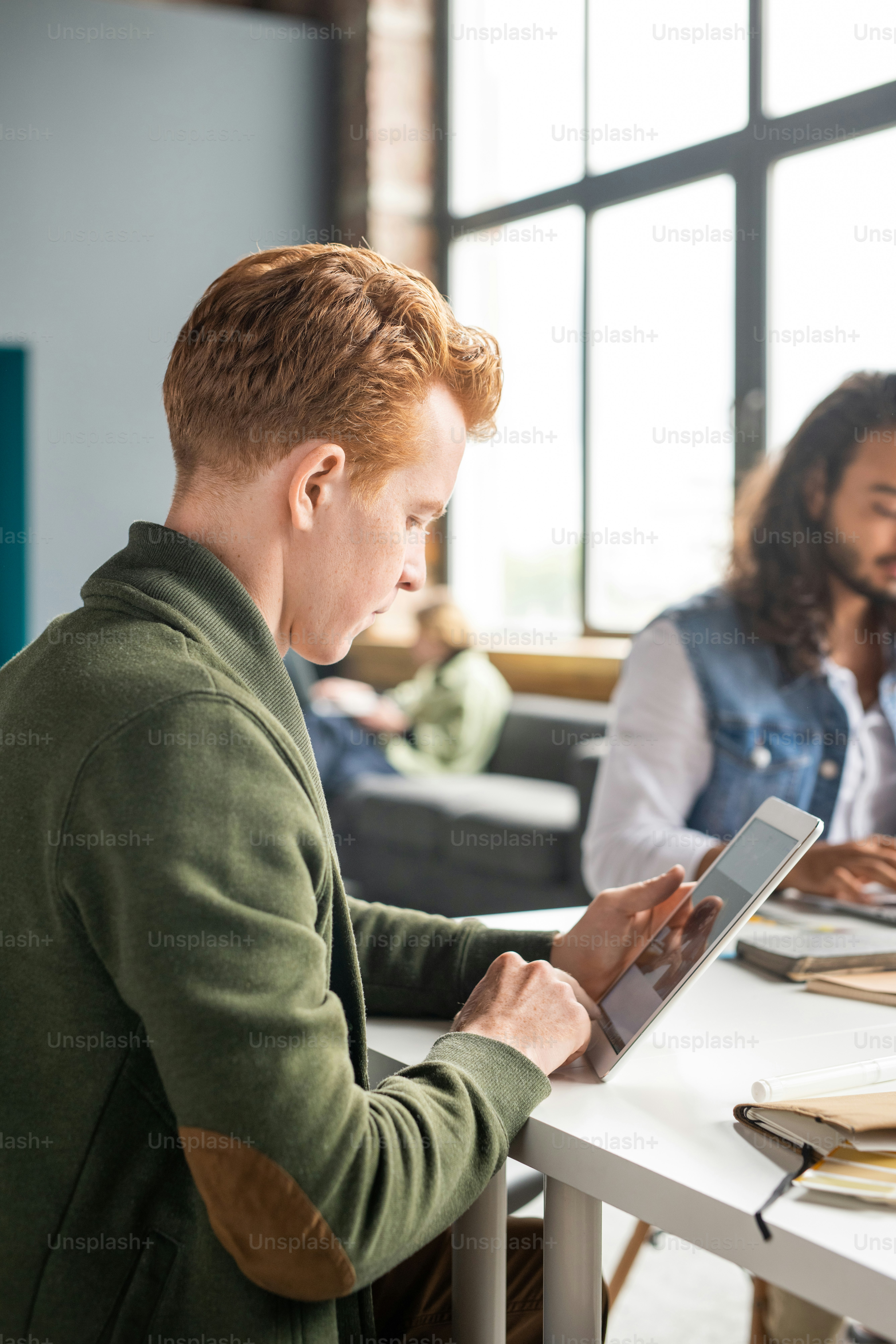 Young contemporary software developer scrolling through sketches of new ...