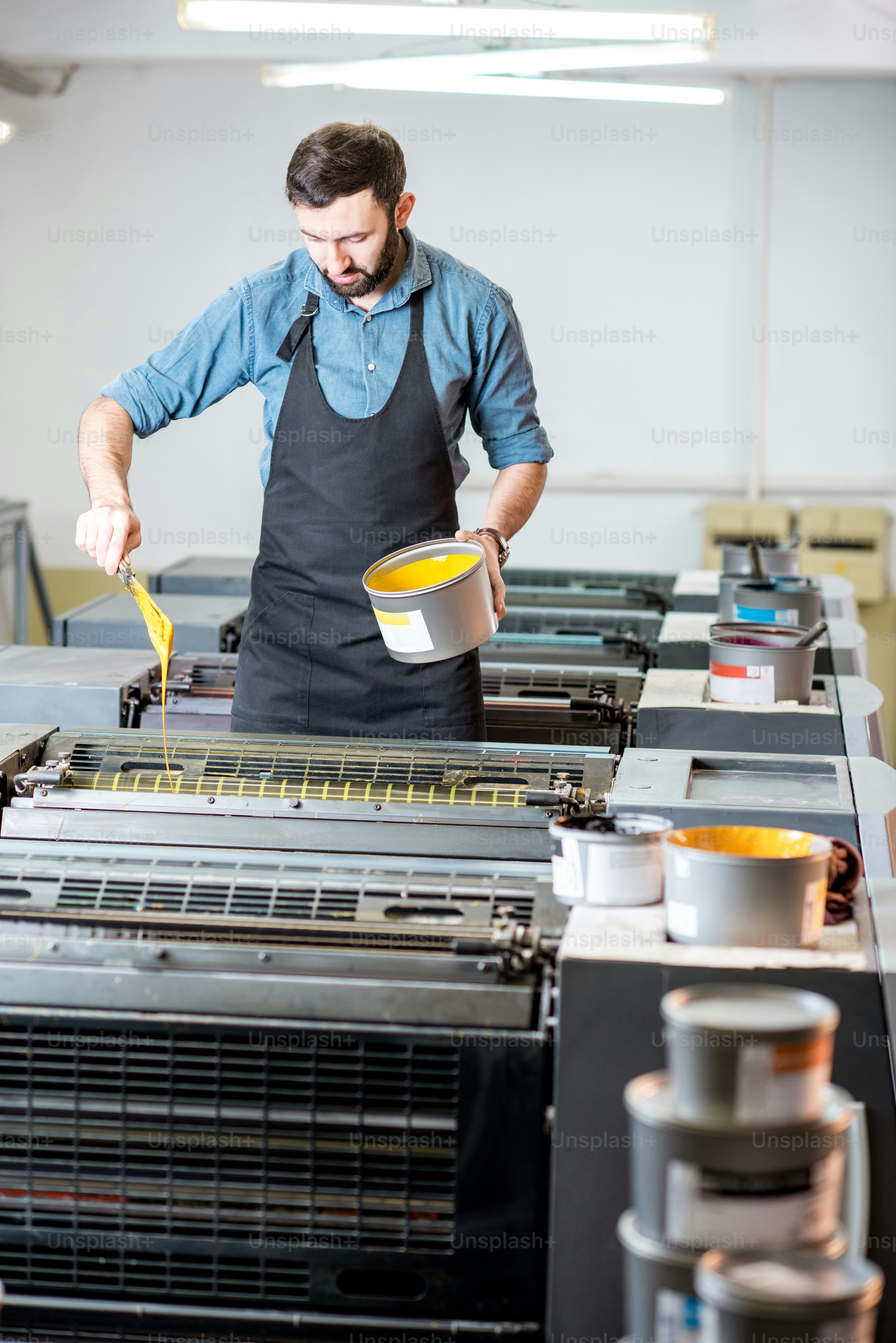Typographer checking printing quality standing near the old press ...