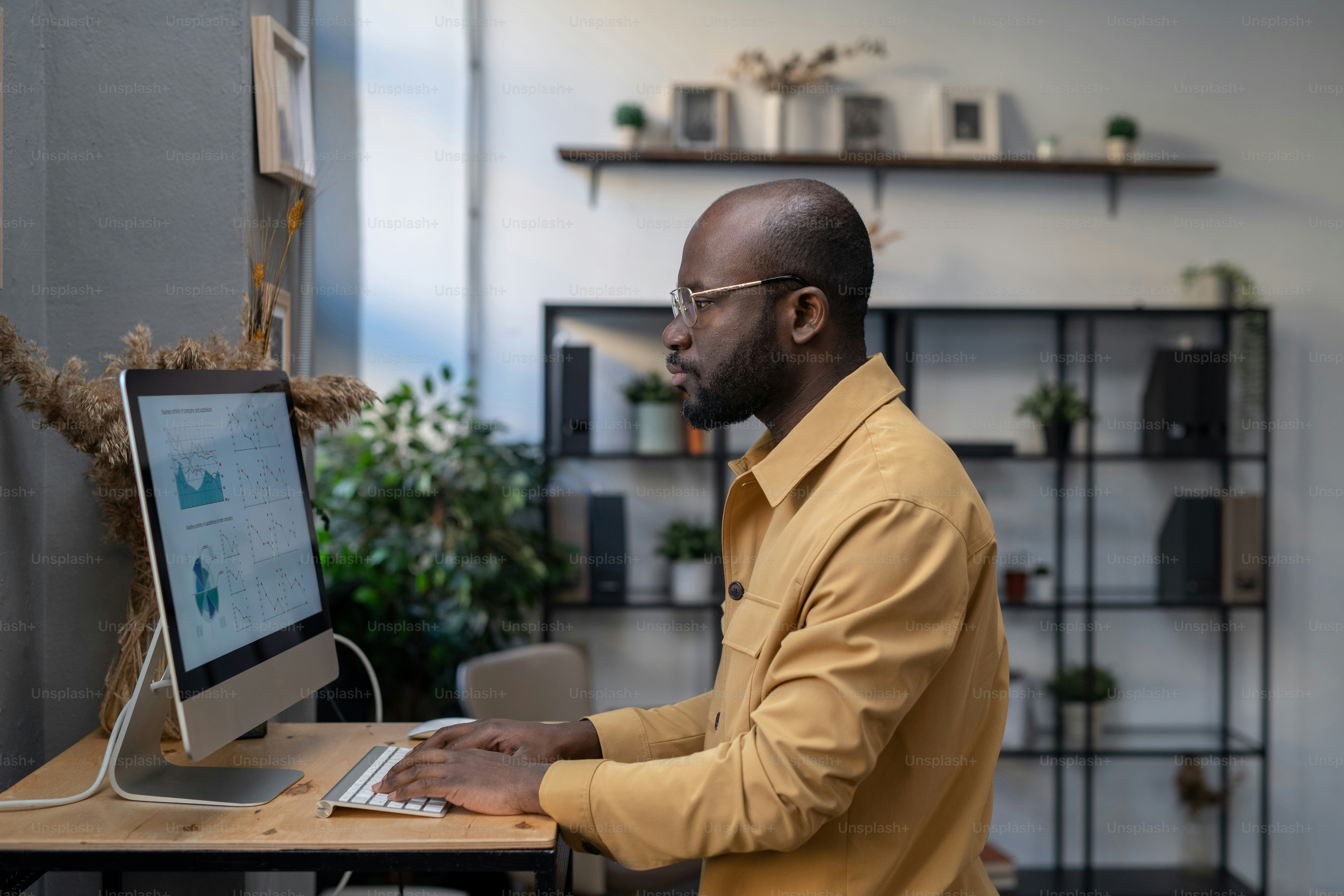 Side view of young African-American financial manager in casual shirt ...