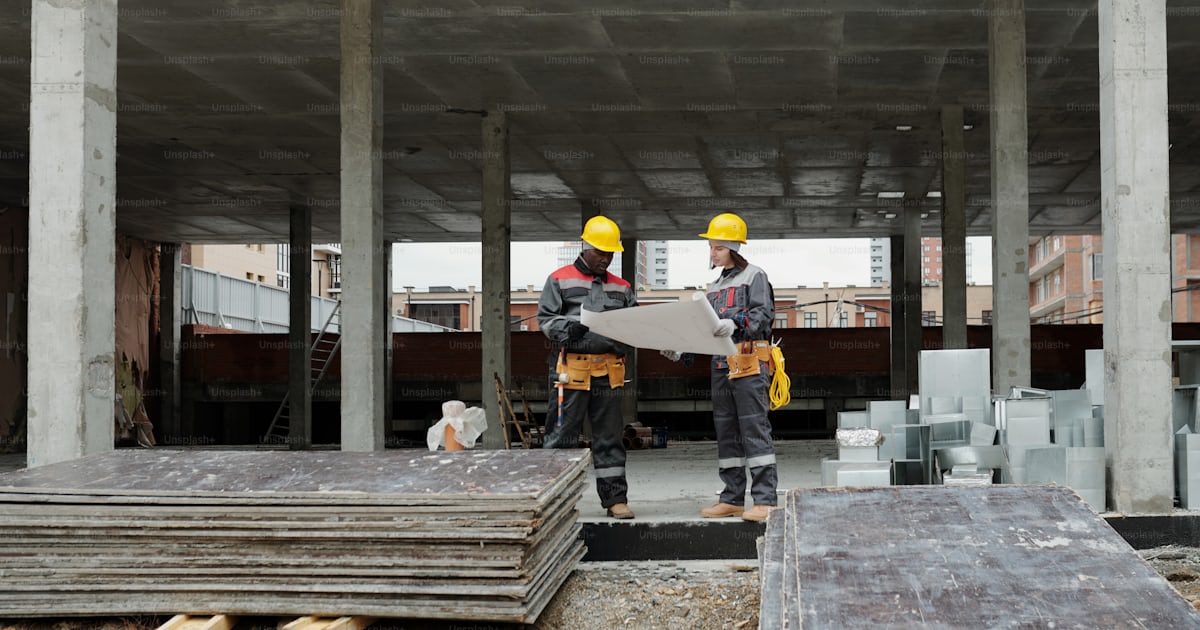 Deux bâtisseurs interculturels modernes en tenue de travail discutent d ... Deux bâtisseurs interculturels modernes en tenue de travail discutent d ...