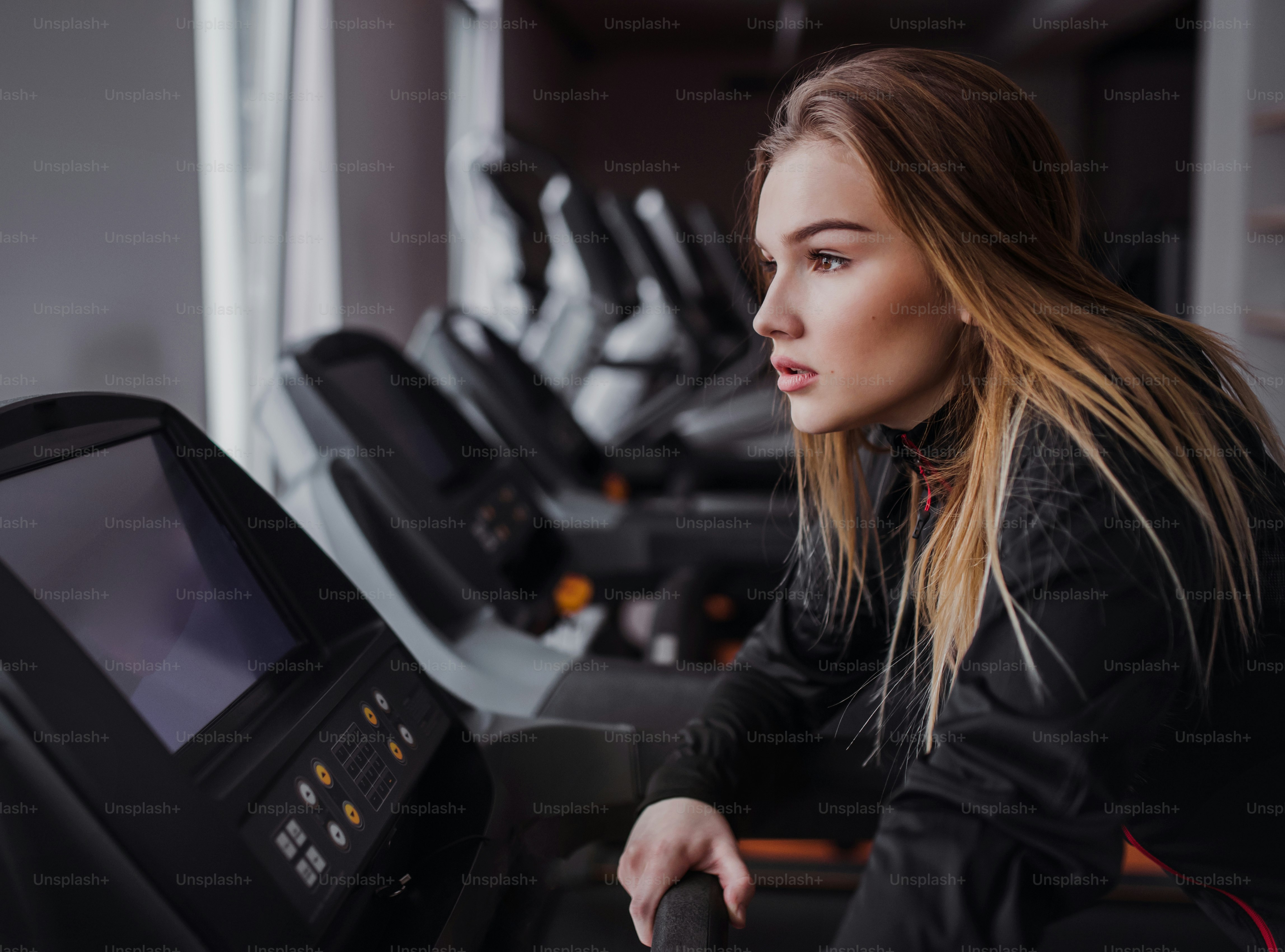 A portrait of a beautiful young girl or woman doing cardio workout in a ...