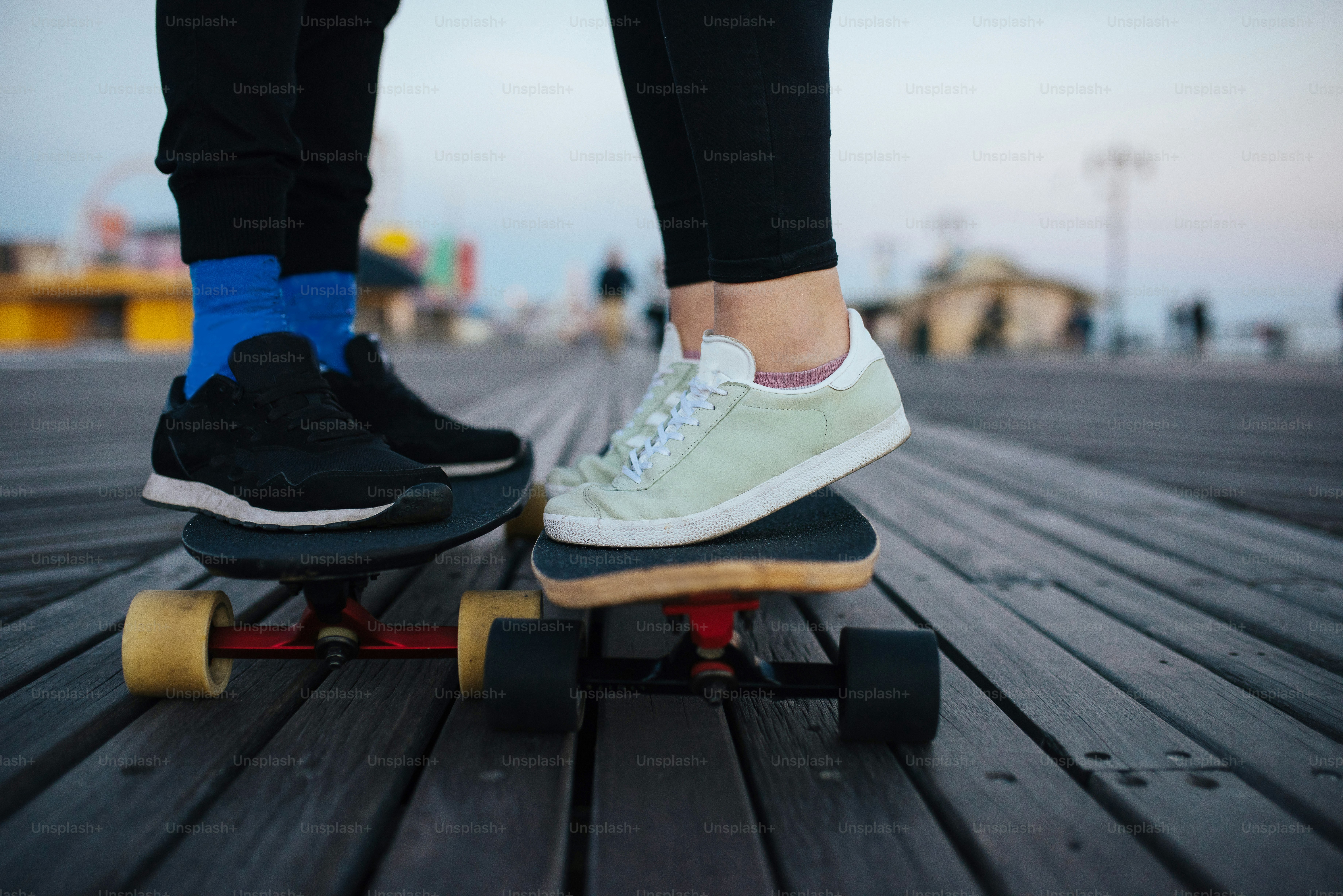 Young teenage couple riding longboards on boardwalk Coney Island, New ...