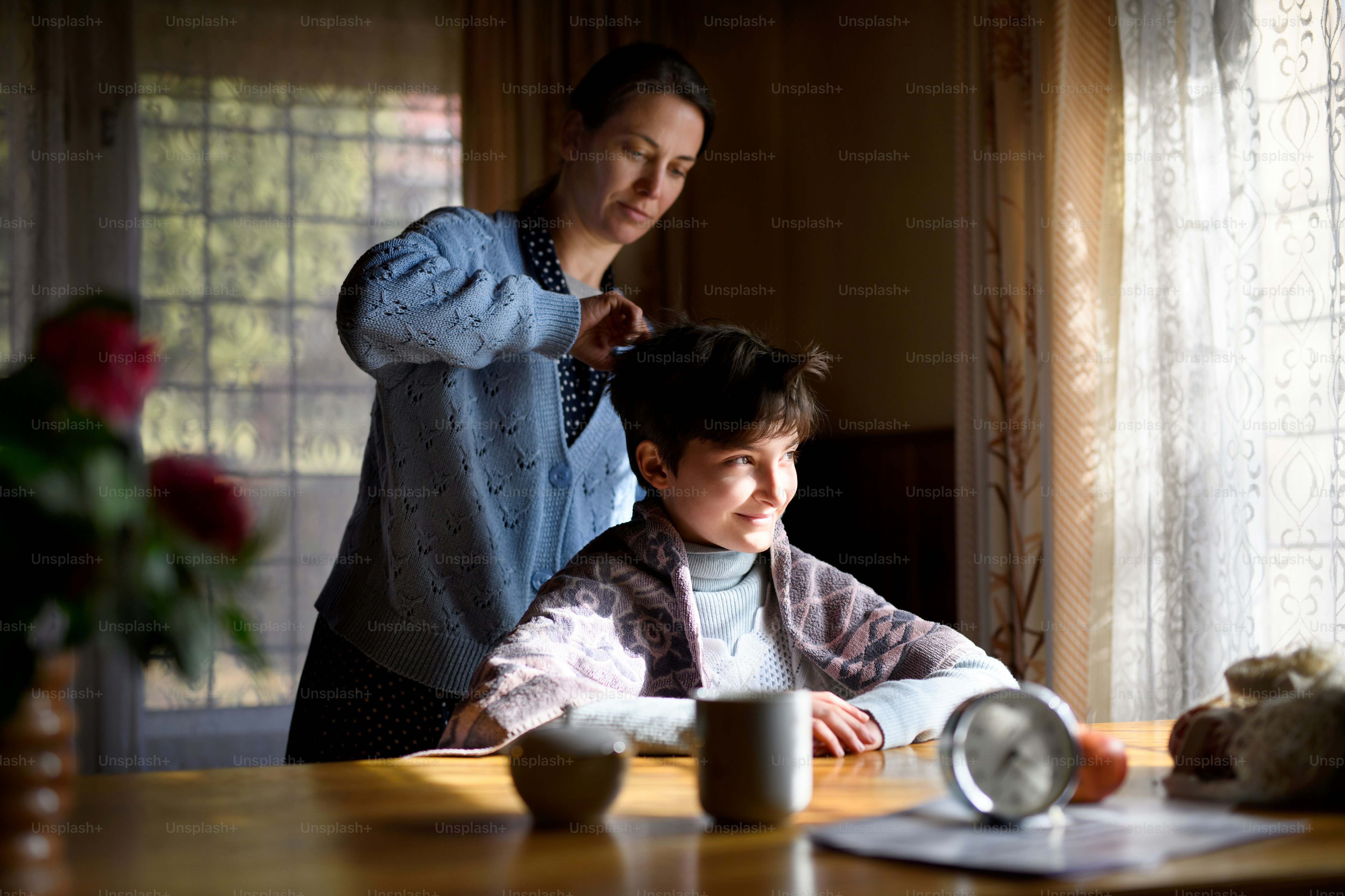 Portrait of sad poor woman cutting daughter's hair indoors at home ...