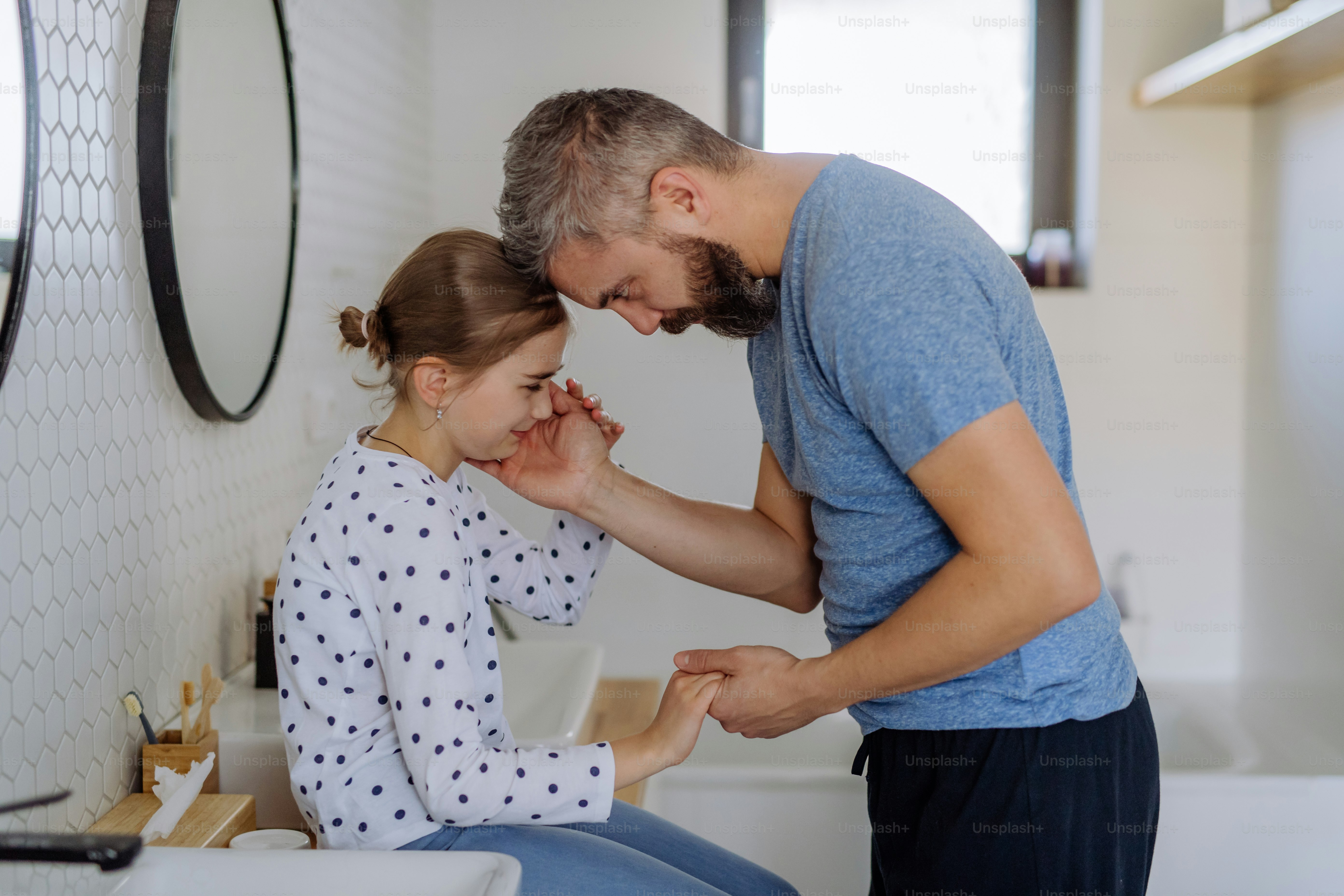 A father consoling his little upset daughter in bathroom at home. photo – Morning Image on Unsplash