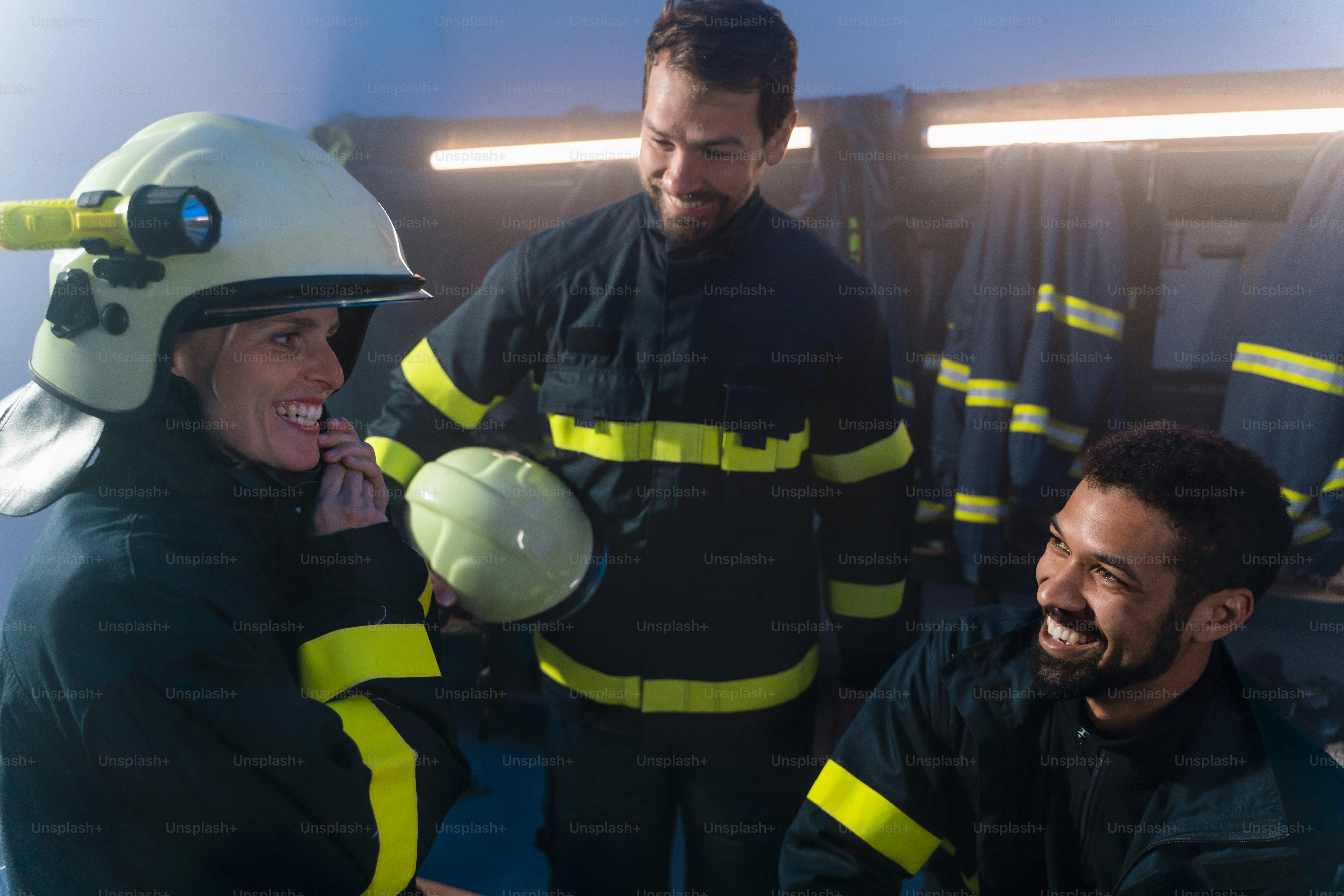 Happy firefighters men and woman talking after an action indoors in ...