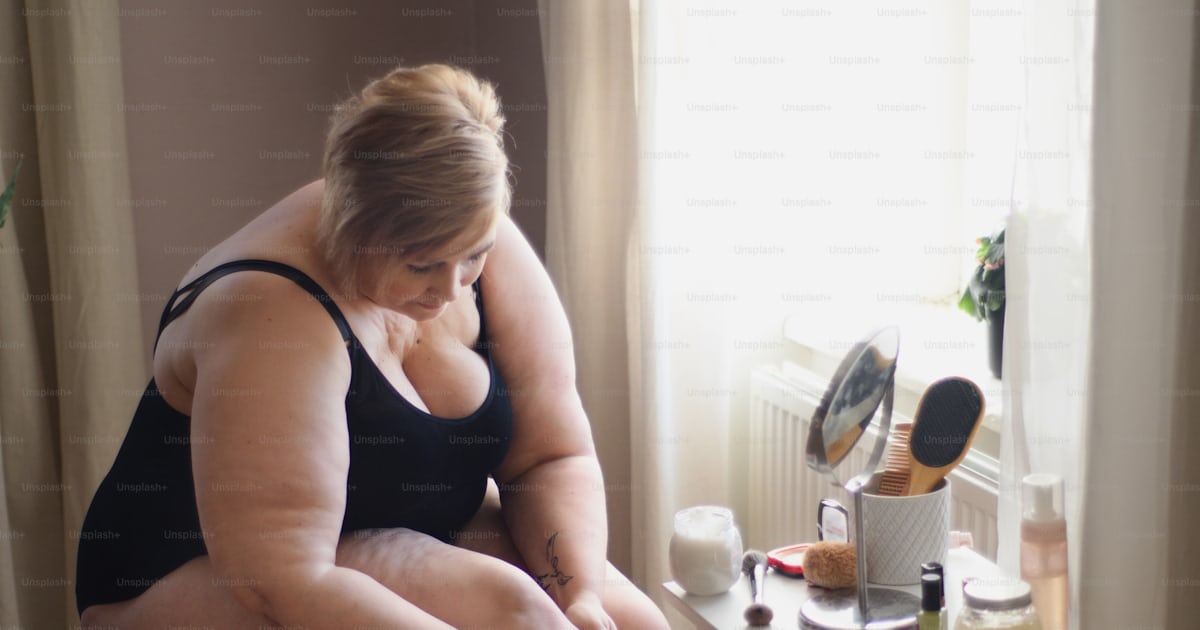 뚱뚱한 여자가 앉아서 집에서 다리에 크림을 바르는 자기 관리 개념 사진 Unsplash의 속옷 이미지
