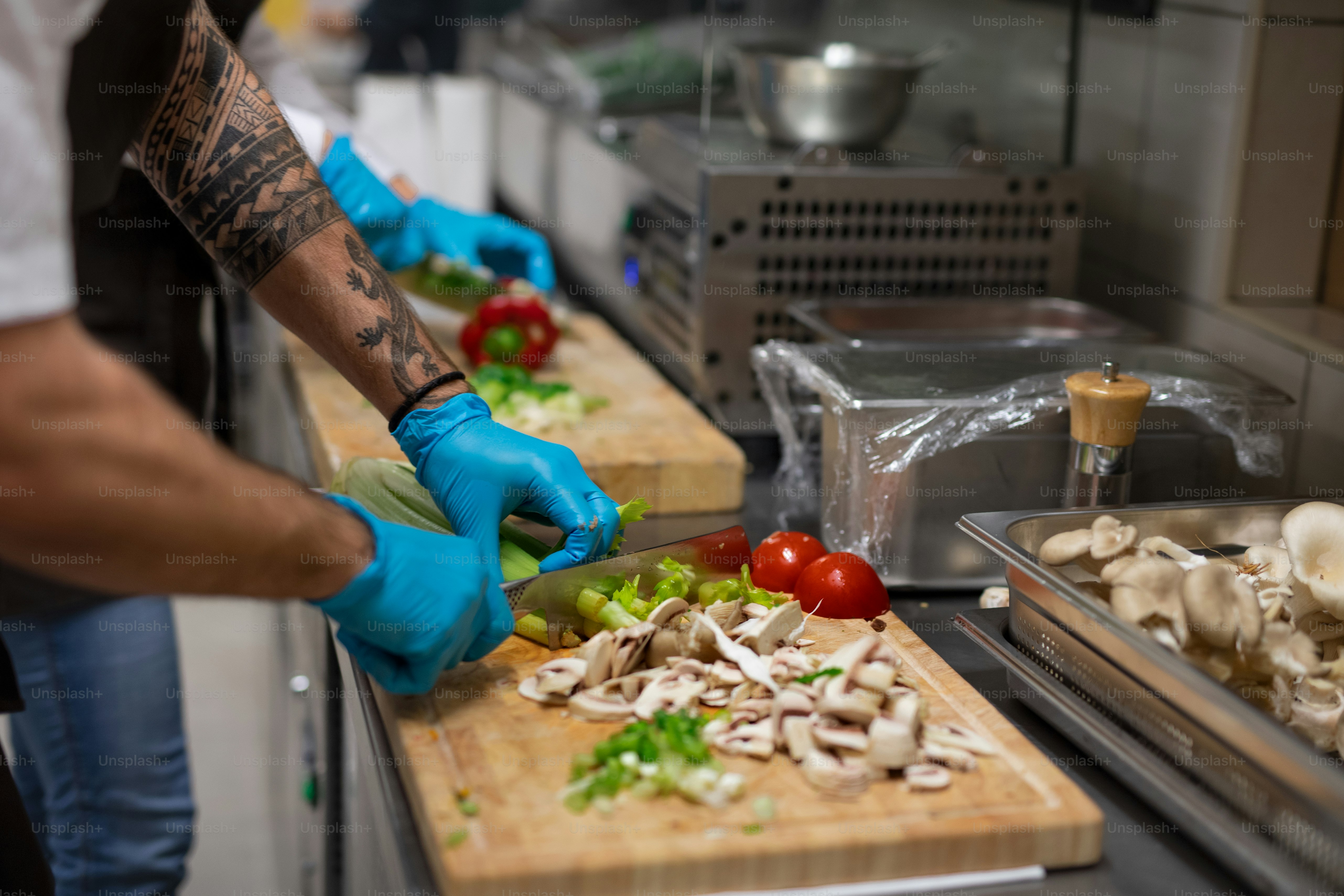 A close-up of cook washing vegetables in sink in commercial kitchen ...