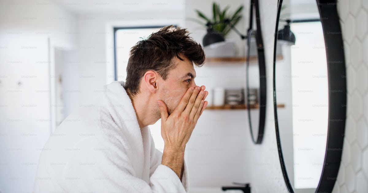 Foto Joven Lavándose La Cara En El Baño Por La Mañana Una Rutina