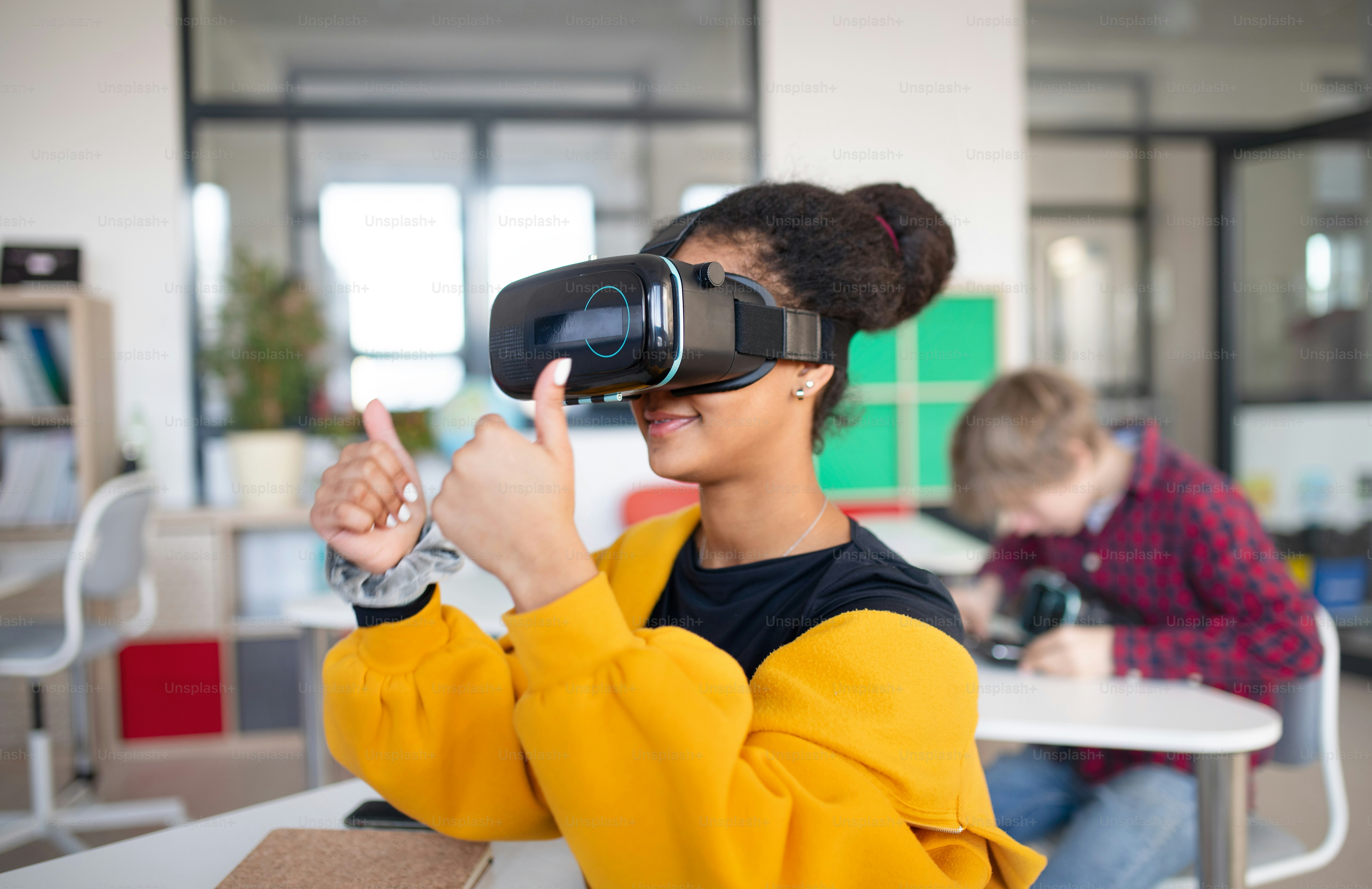 A happy student wearing virtual reality goggles at school in computer ...