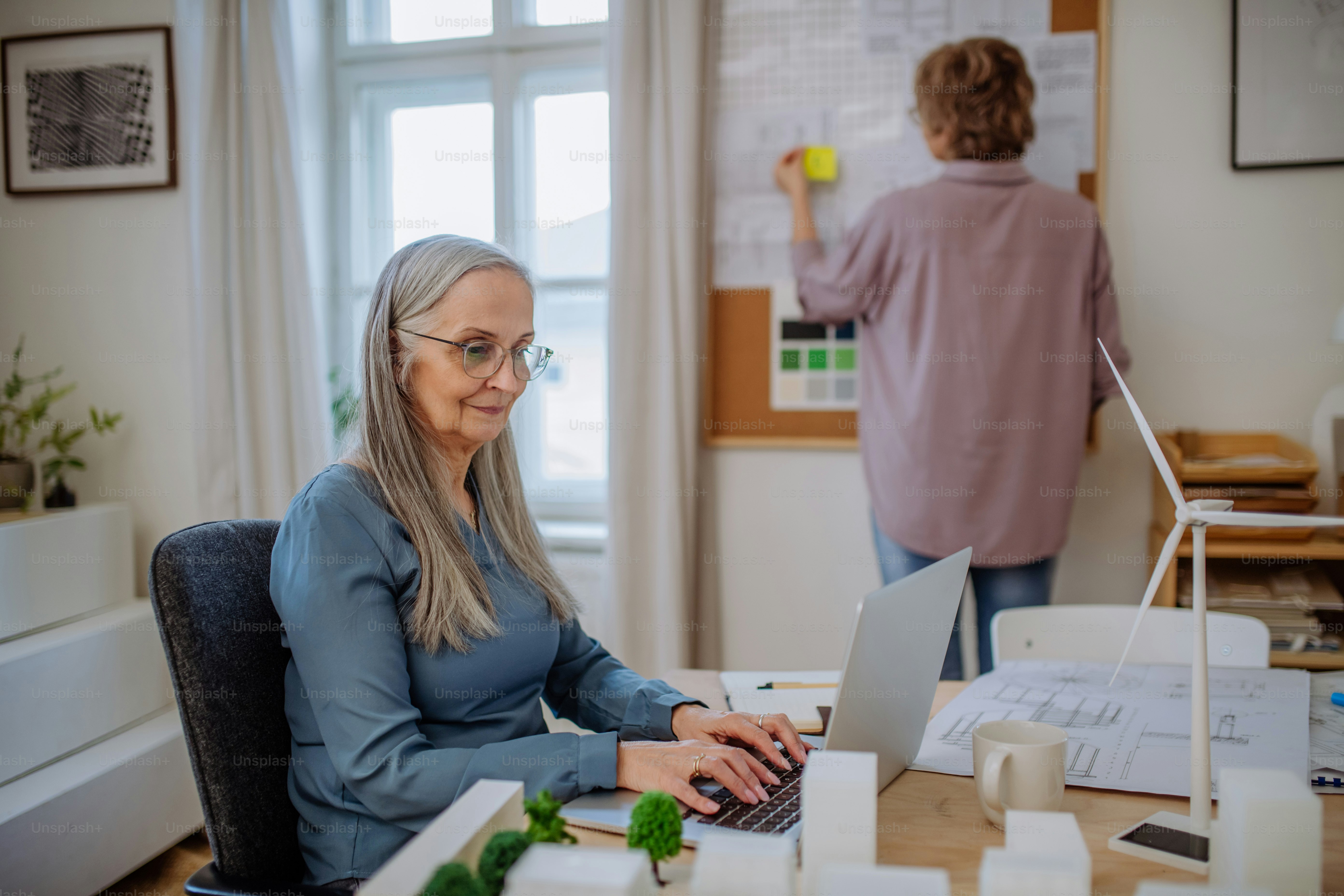 Happy mature women eco architects working together in an office. photo ...