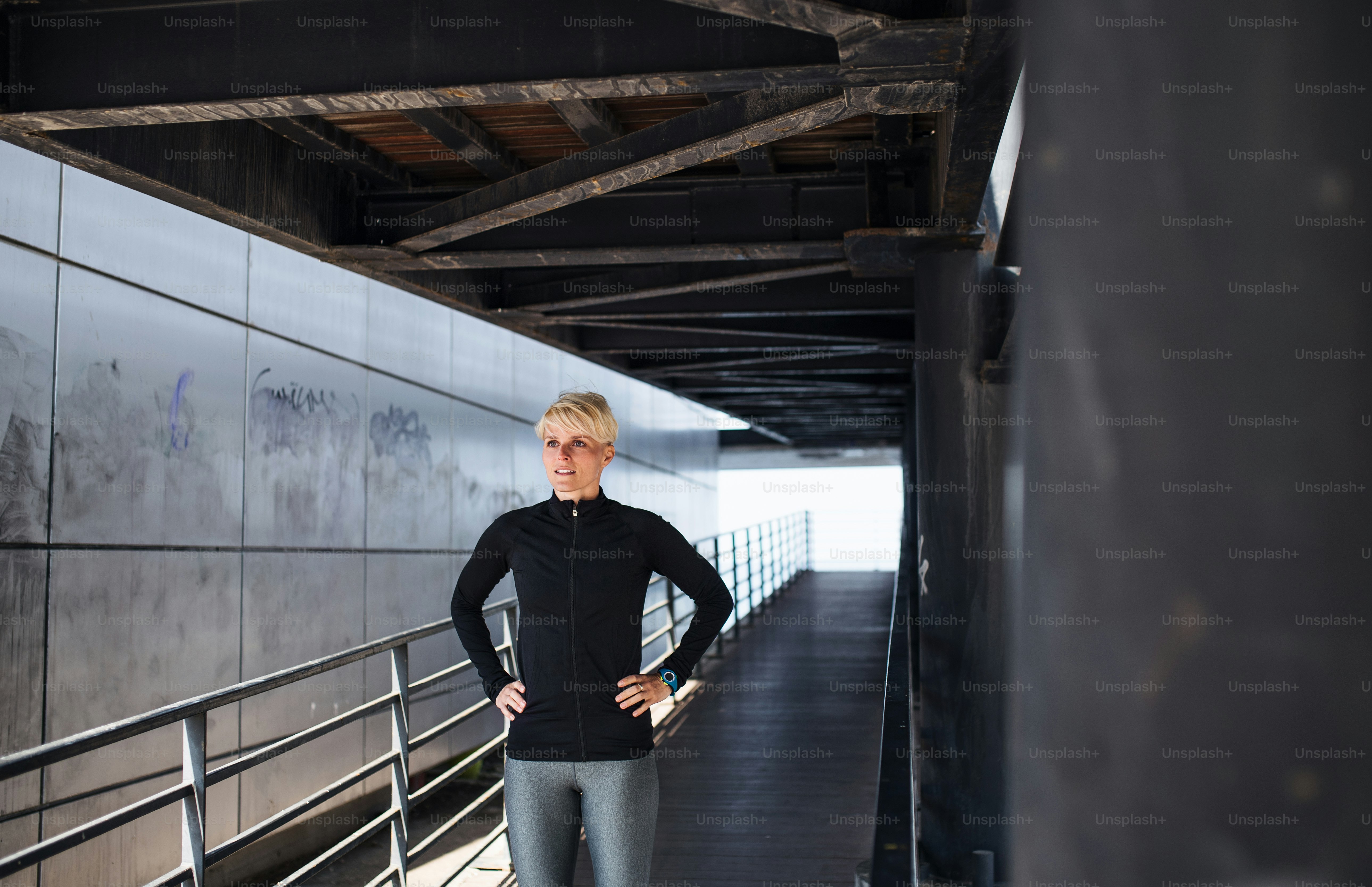 A young sportswoman doing exercise outdoors in city, resting. photo ...