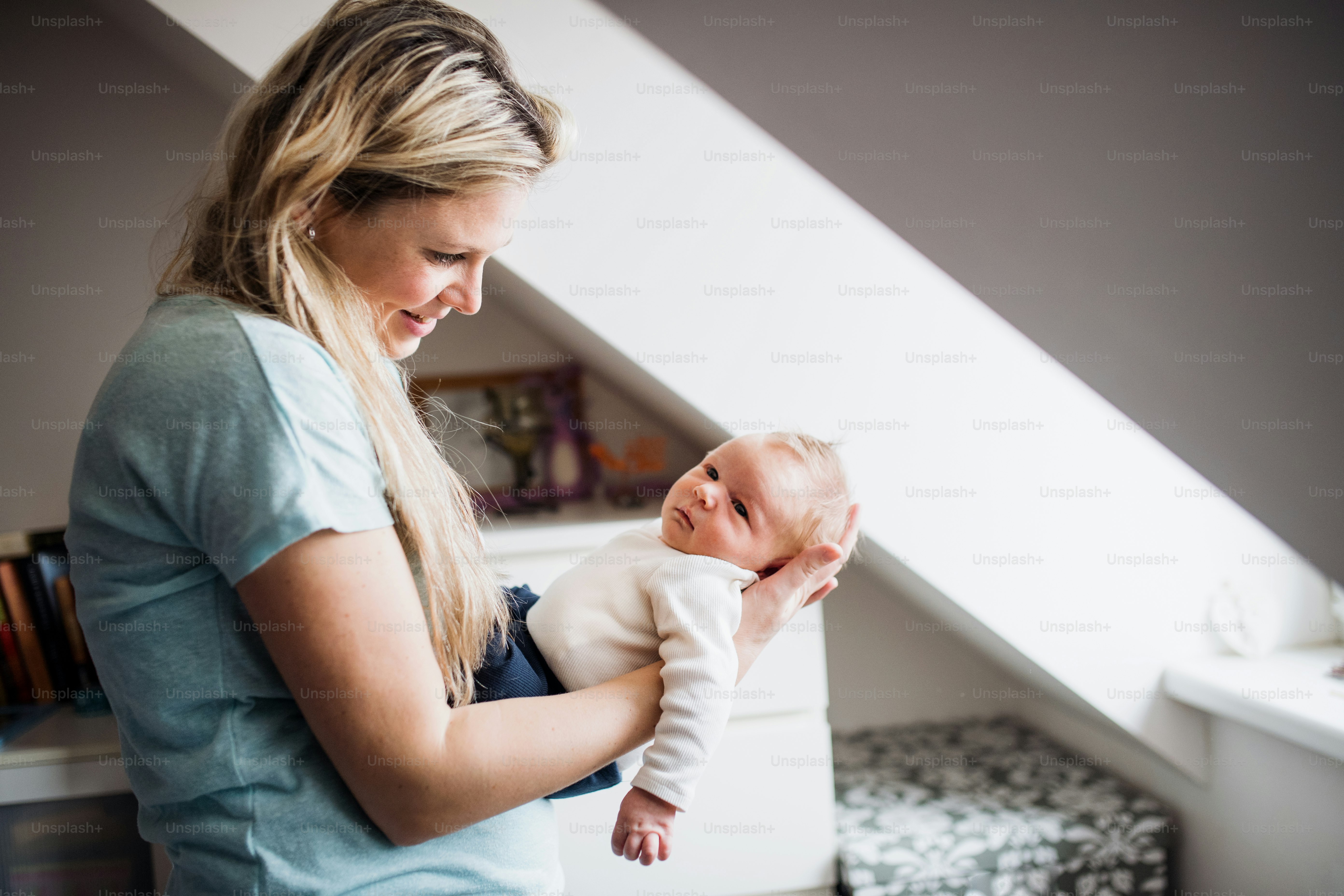 A beautiful young mother holding a newborn baby at home. photo – Family ...