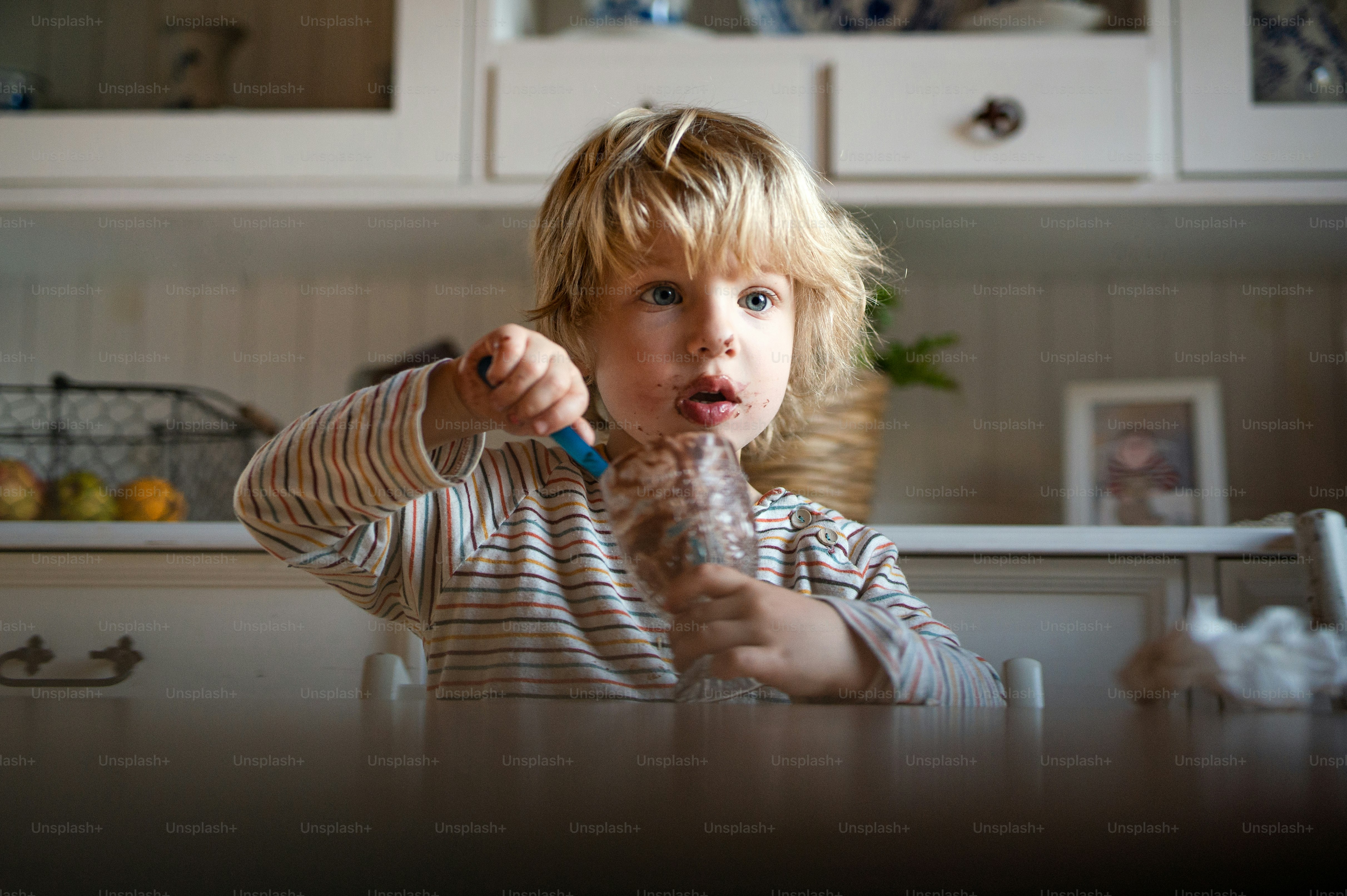 Portrait of small boy with dirty mouth indoors in kitchen at home ...