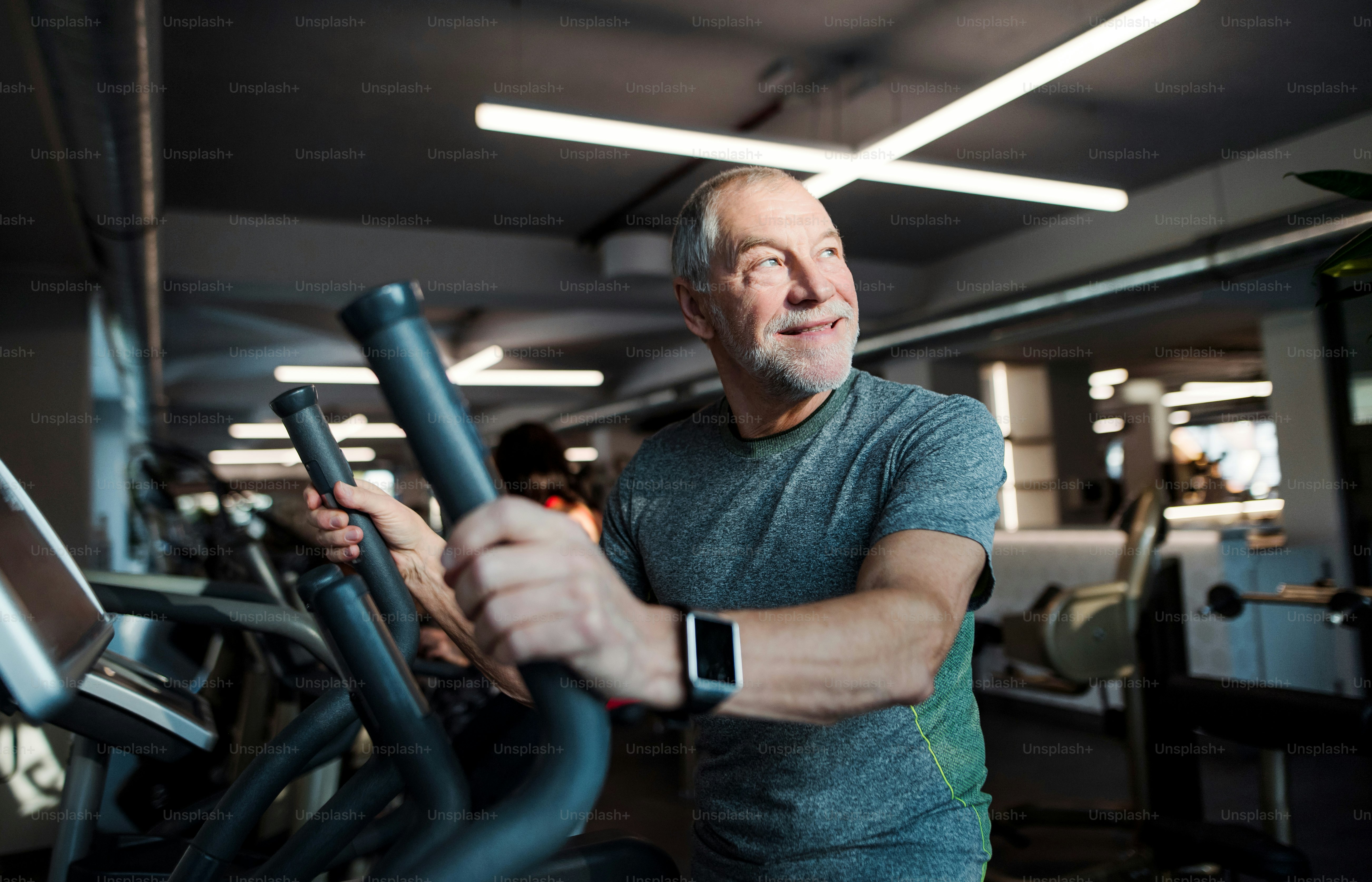 A senior man doing strength workout exercise in gym. A copy space ...