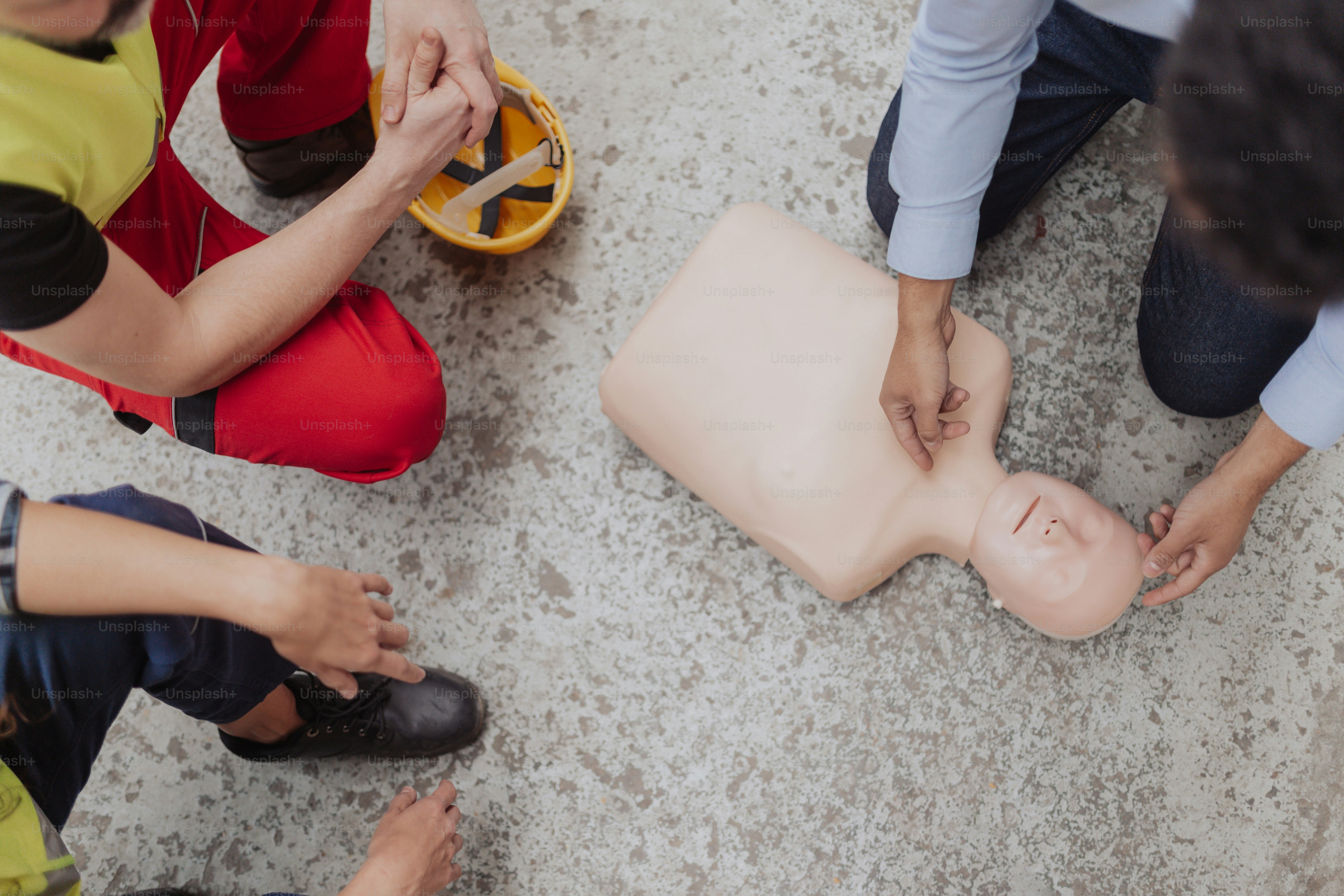 A top view of male instructor showing first medical aid on doll during ...