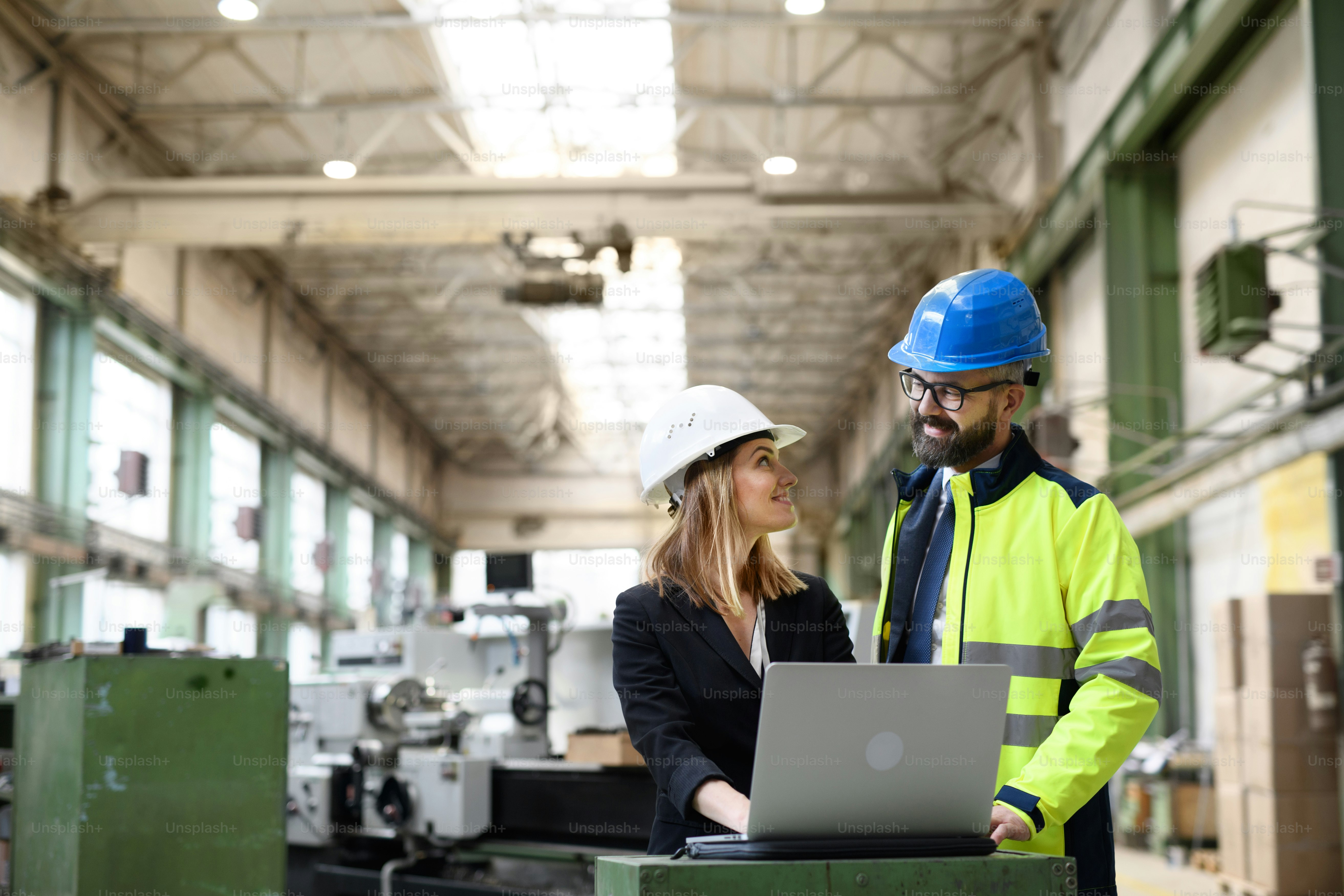 A male and female industrial engineers discussing factory's new ...