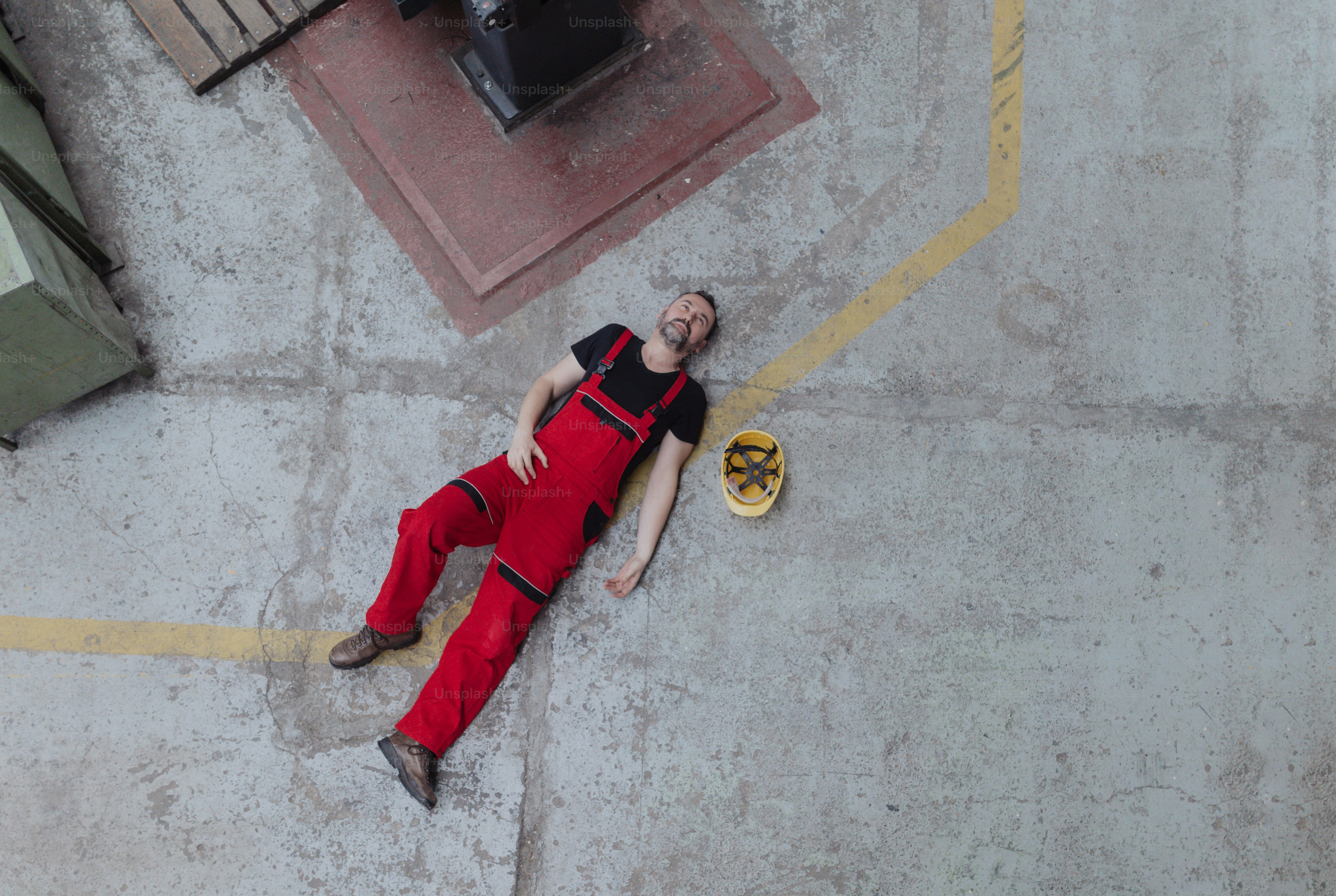 Vue de dessus d’un ouvrier allongé sur le sol après un accident dans ...
