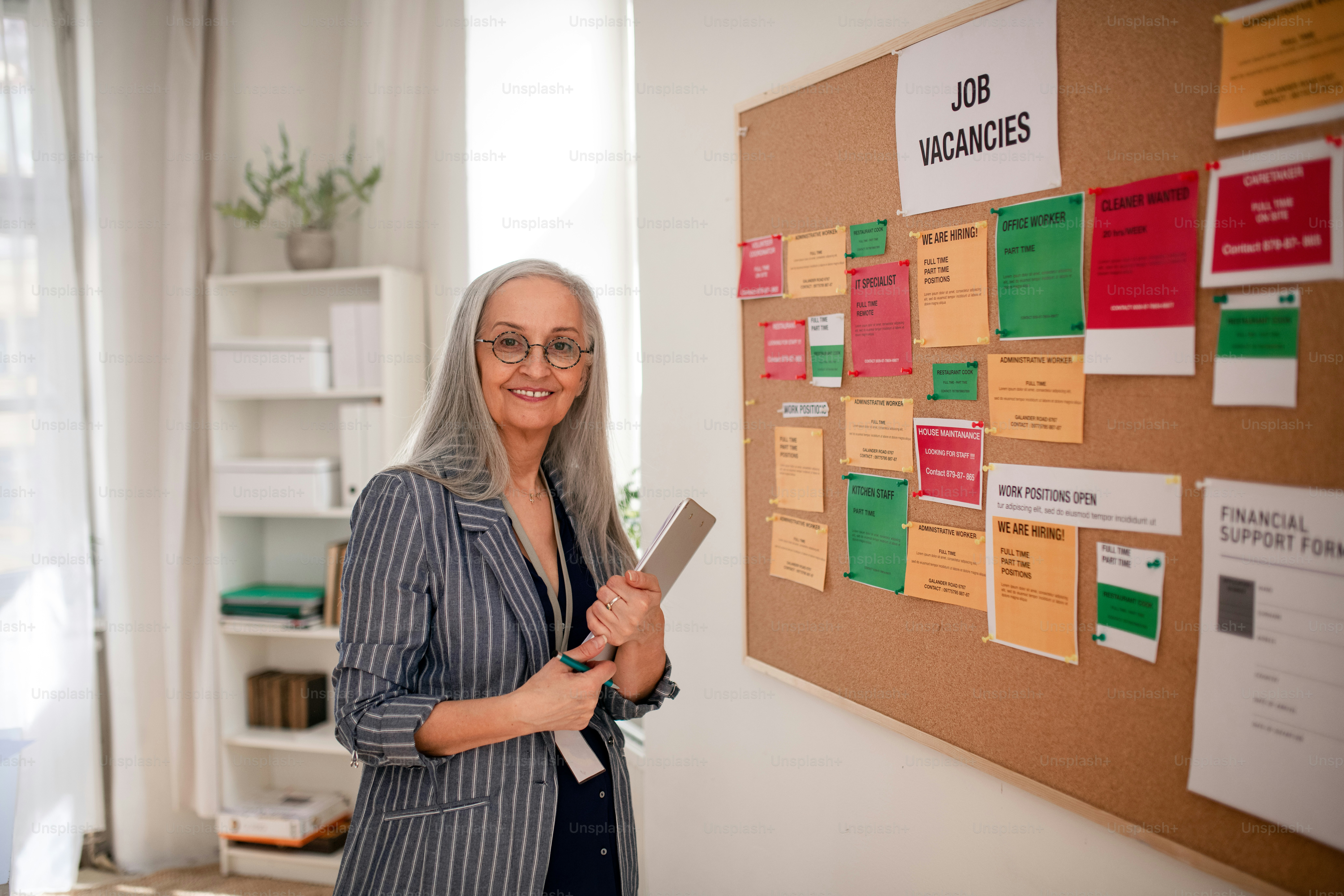 A job center employee with file form standing in front of employment ...