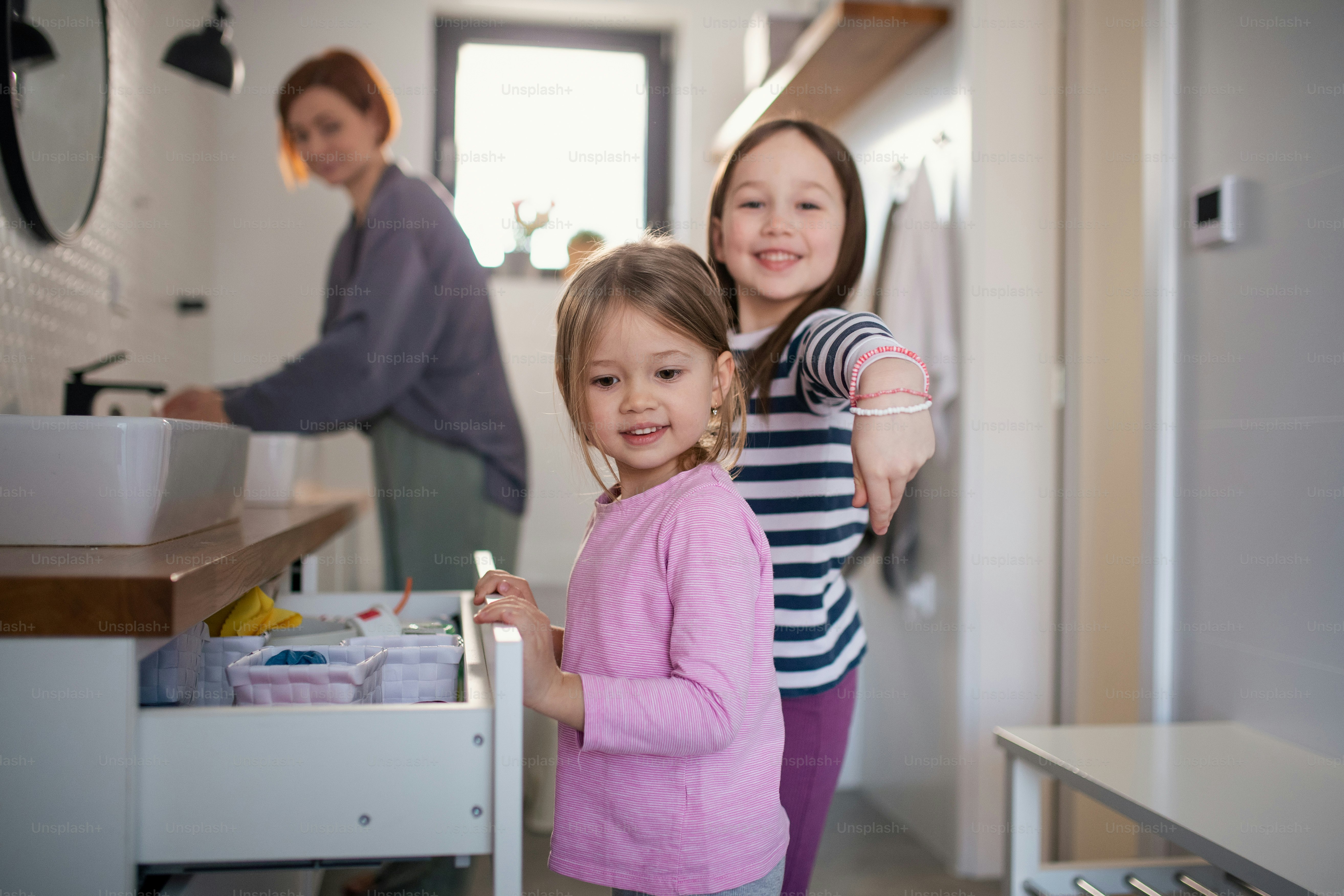 A mother with little children in bathroom, morning routine concept ...