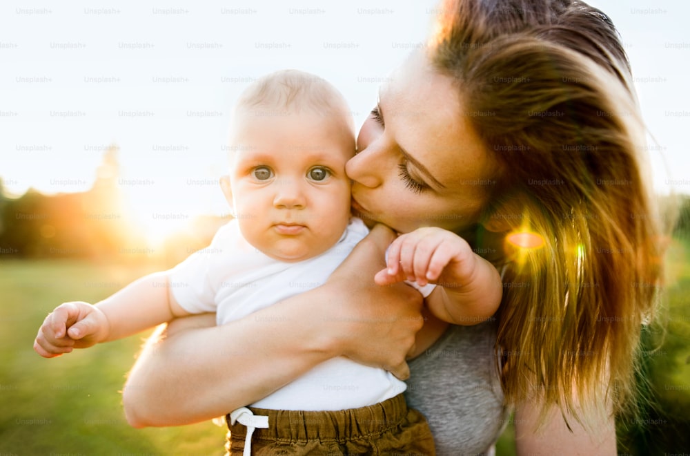 Belle jeune mère tenant son bébé dans ses bras. Une mère embrasse son ... Belle jeune mère tenant son bébé dans ses bras. Une mère embrasse son ...