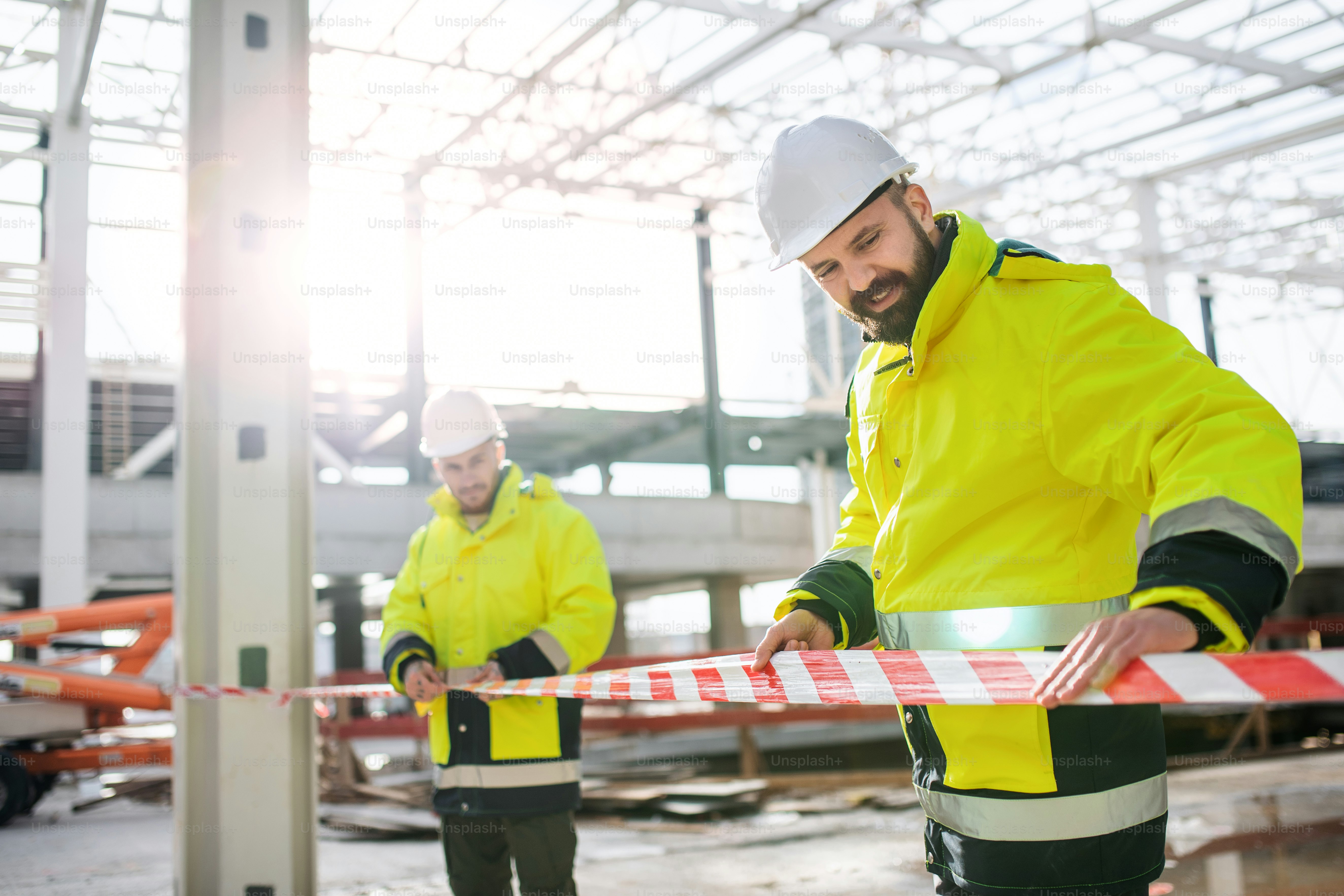 Men workers standing outdoors on construction site, working in winter ...