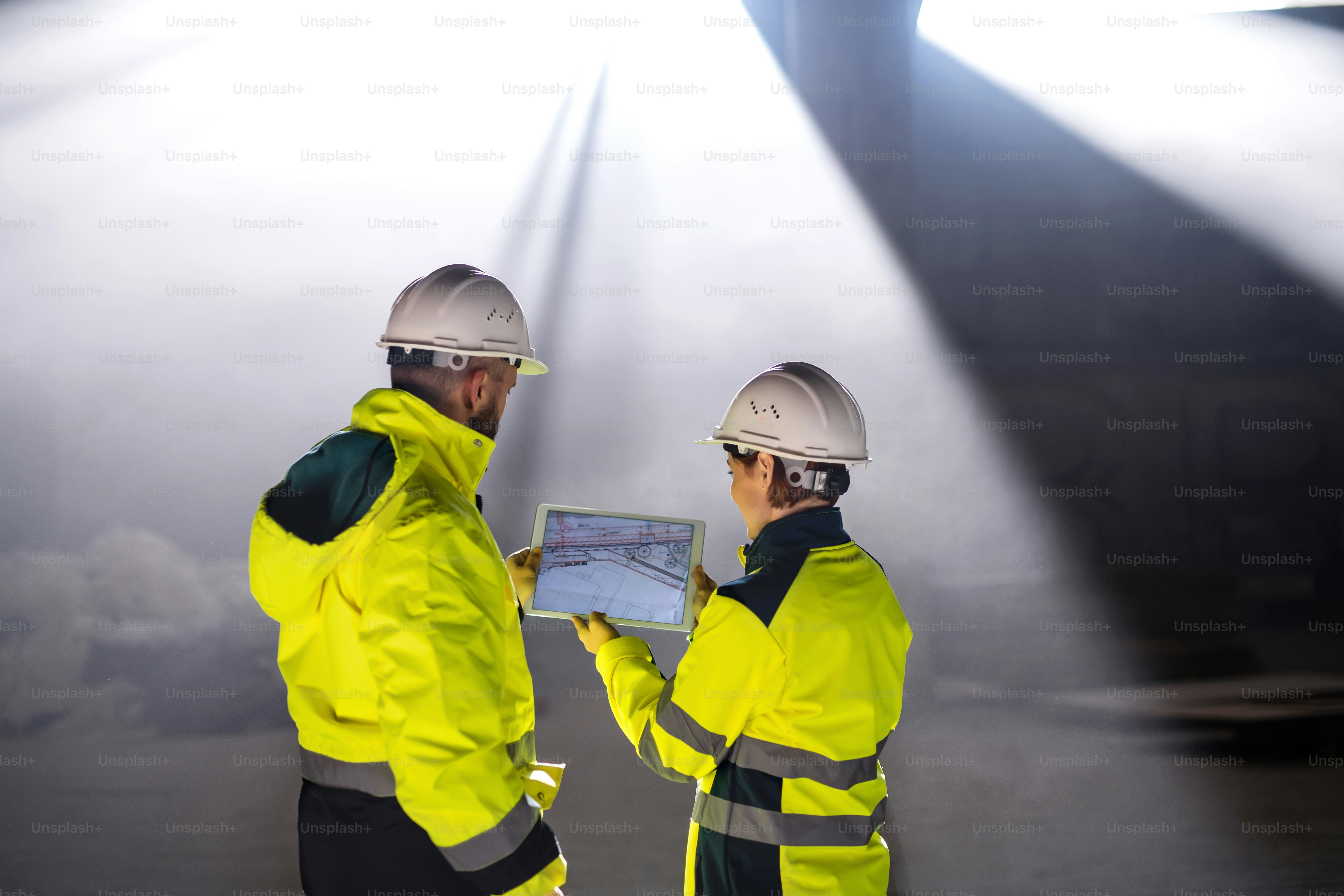 A group of male and female engineers standing on construction site ...