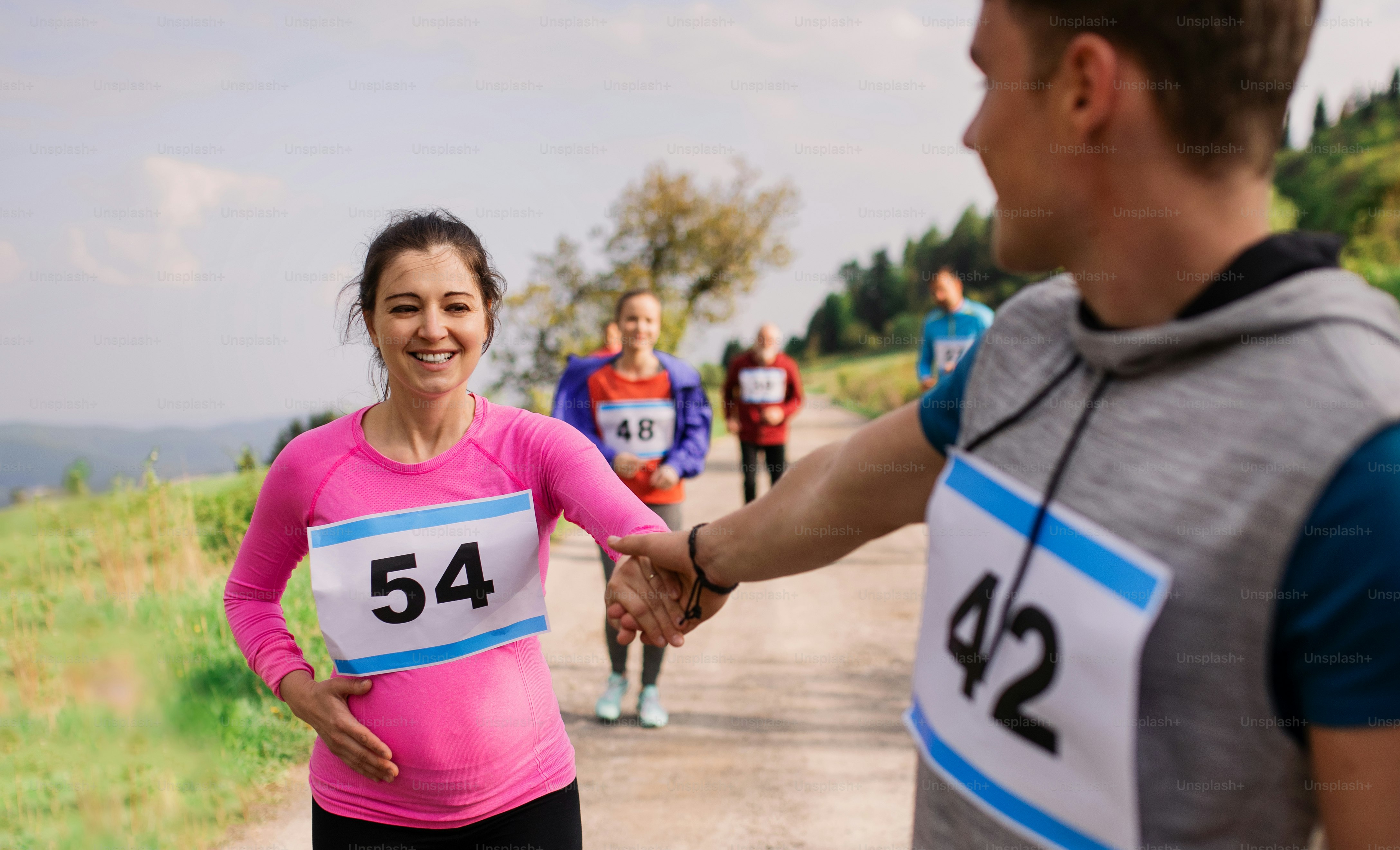 A midsection of large group of people running a race competition in ...