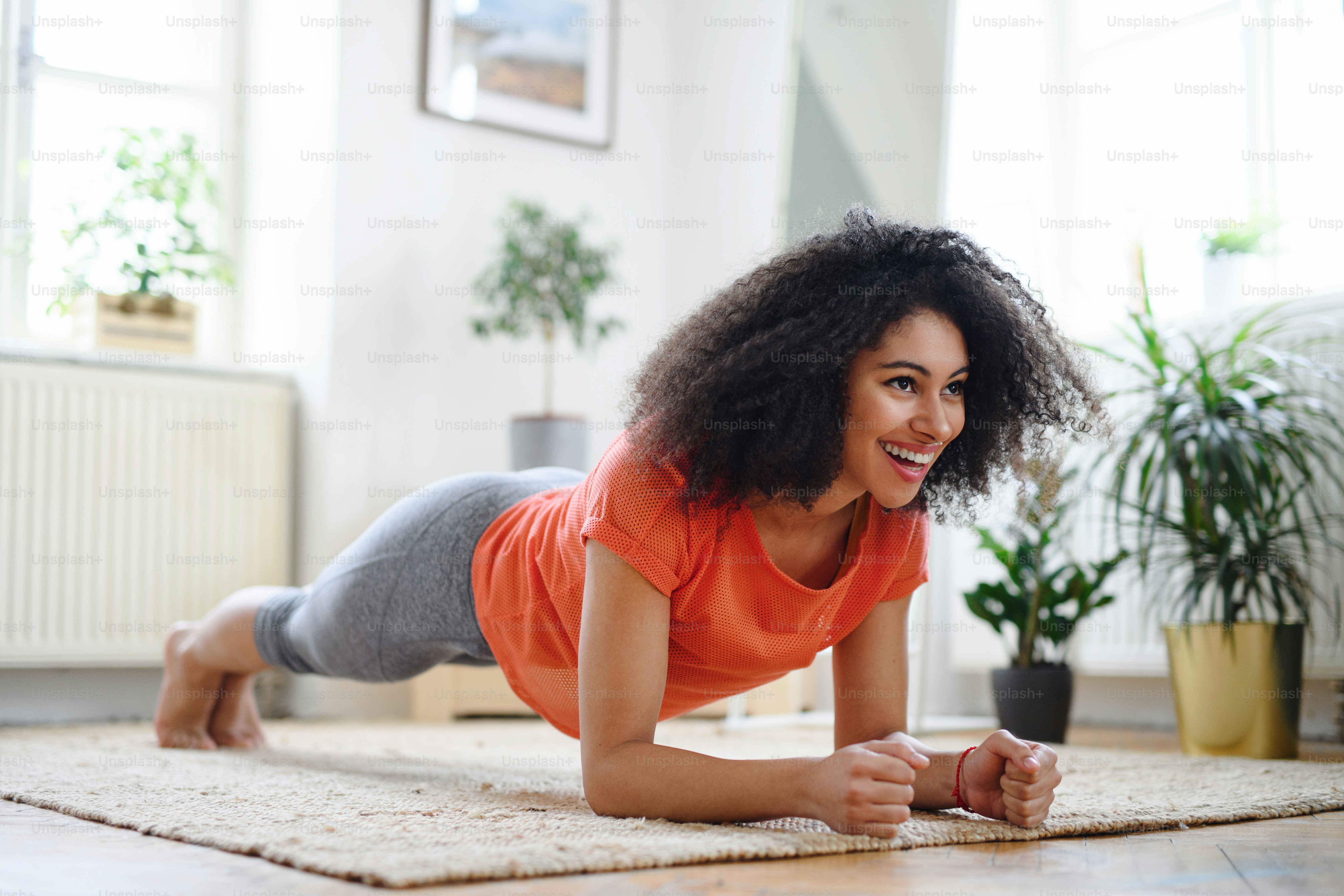 Happy young woman indoors at home, doing exercise. Sport concept. photo ...