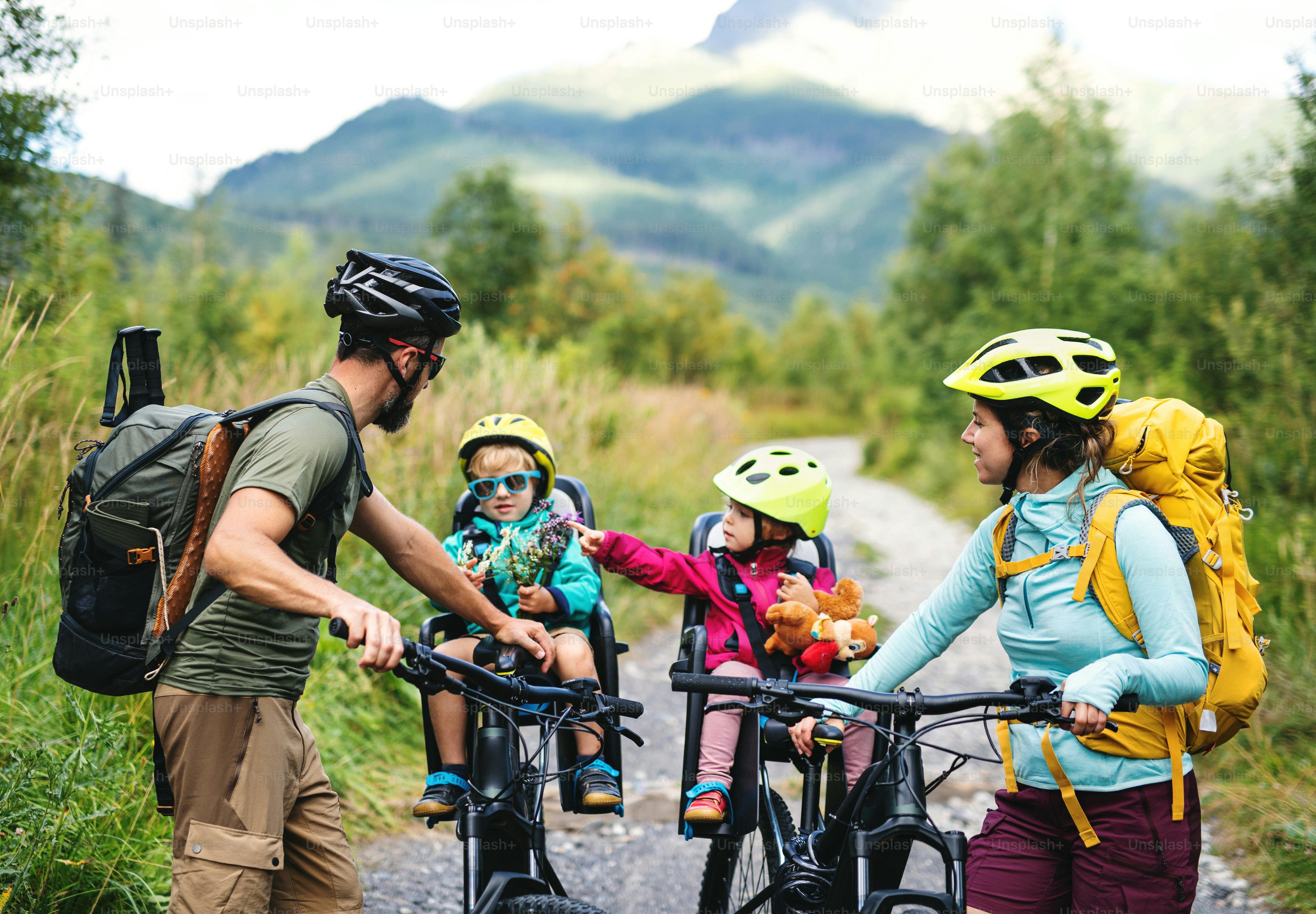 Tired family with small children cycling outdoors in summer nature ...