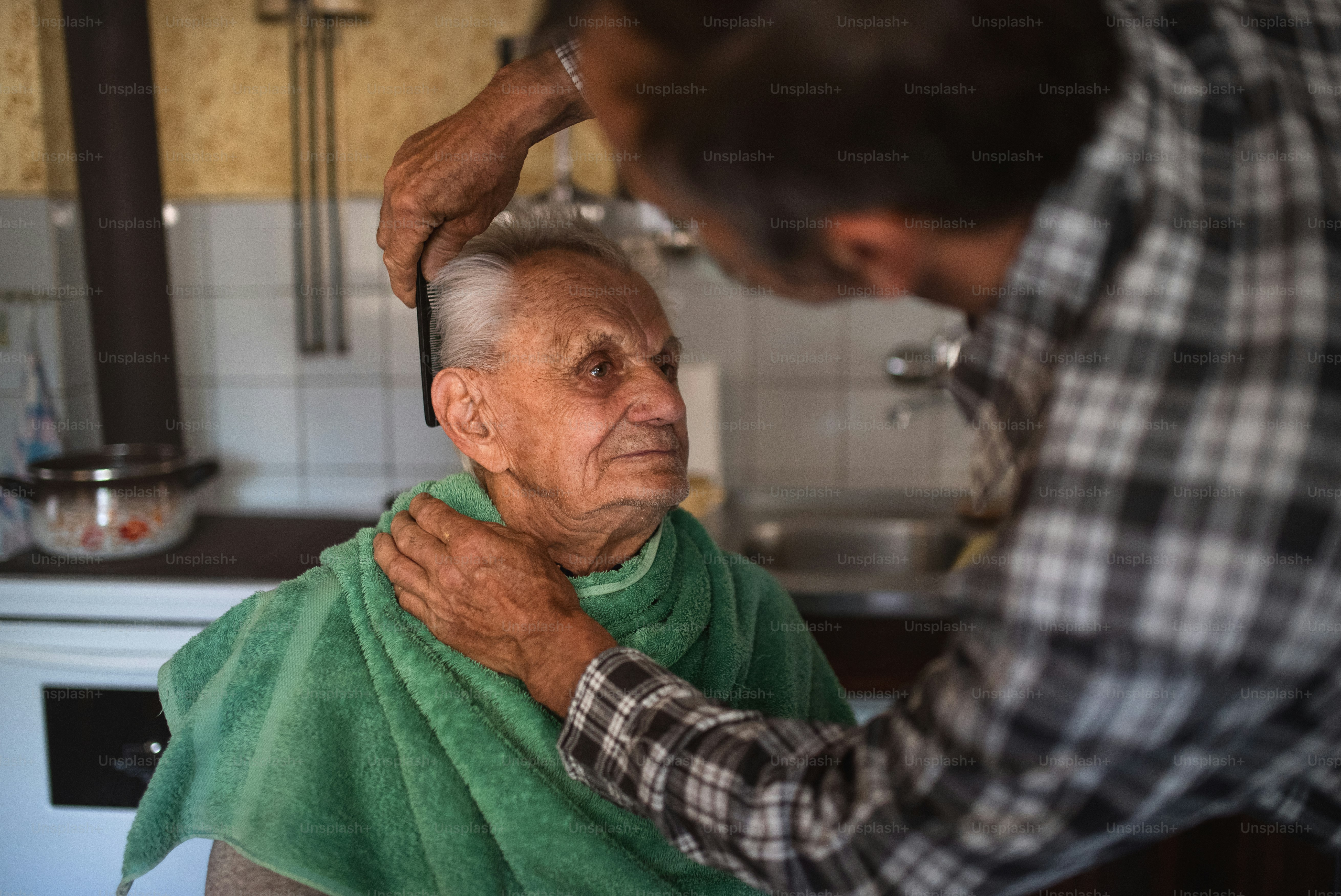 A portrait of man combing hair of elderly father indoors at home. photo ...