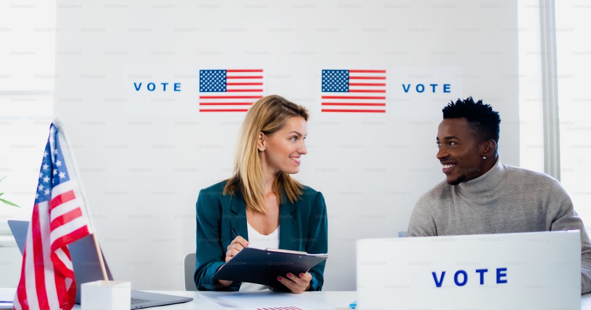 投票所で話している選挙委員会の男女のメンバー、アメリカの選挙。の写真 座っている Unsplashの写真