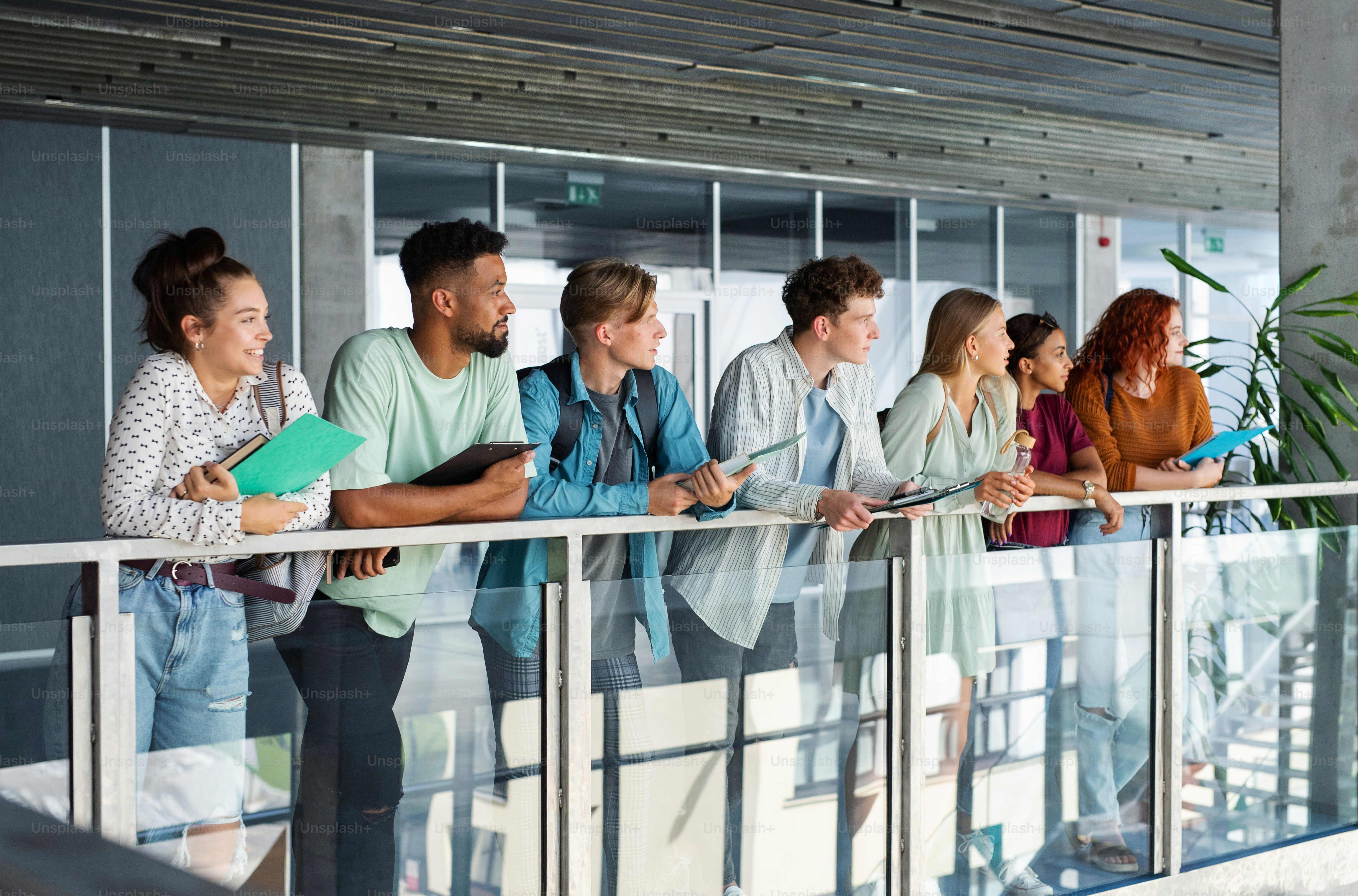 A group of university students standing indoors, back to school concept ...
