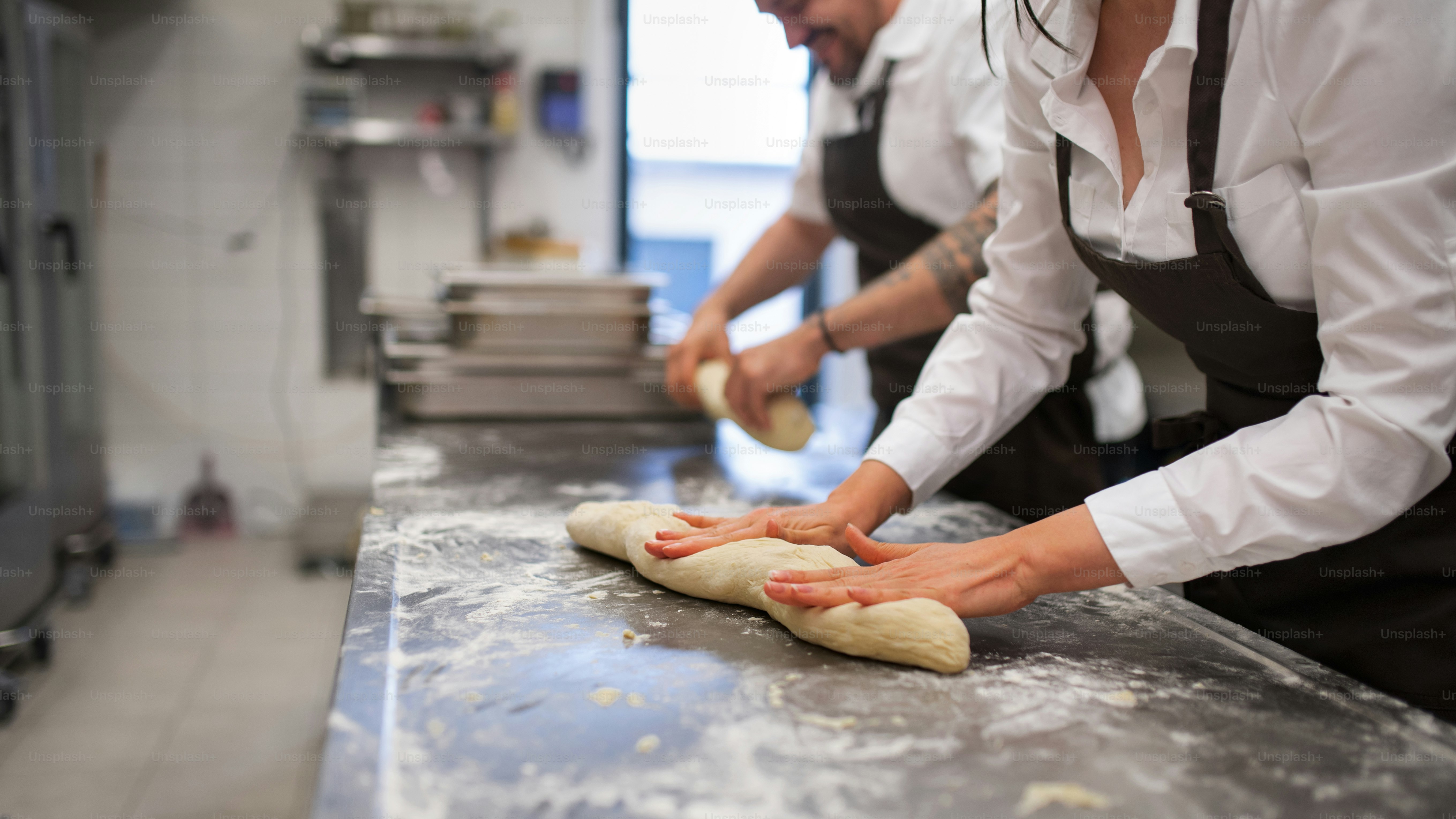 A chef and cook working on their dishes indoors in restaurant kitchen ...