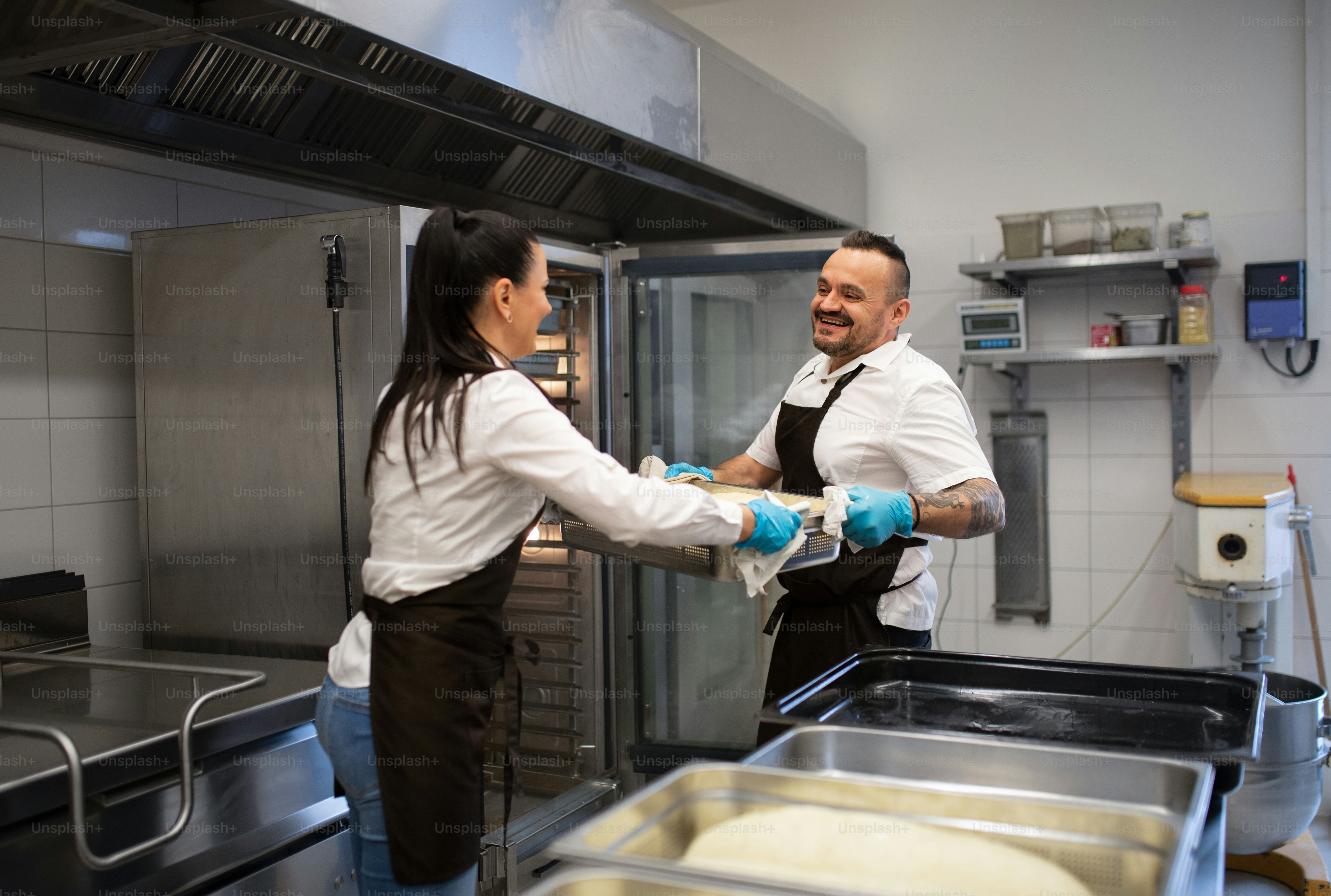 A chef and cook working on their dishes indoors in restaurant kitchen ...