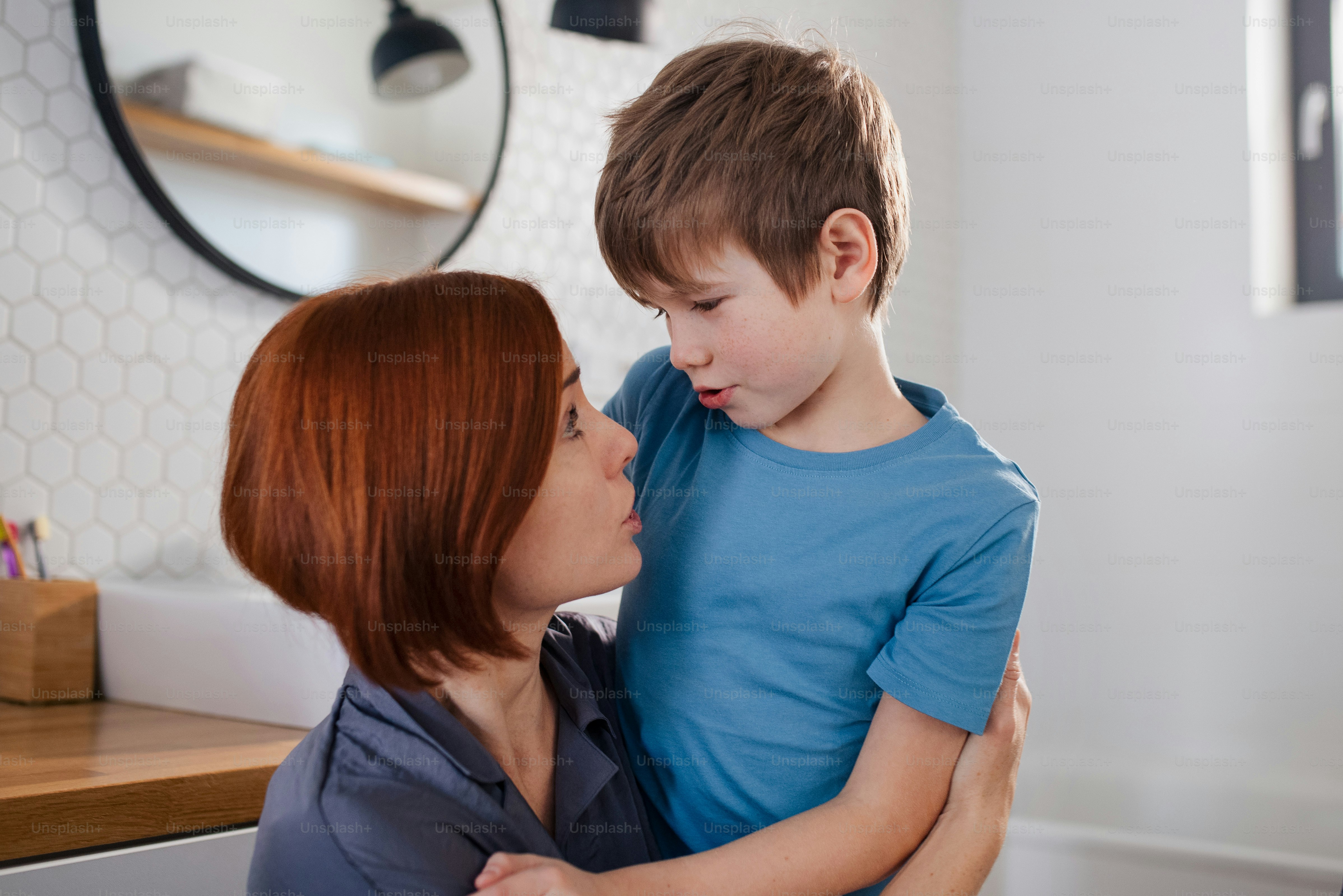 A mother hugging and consoling little boy in bathroom at home. photo ...
