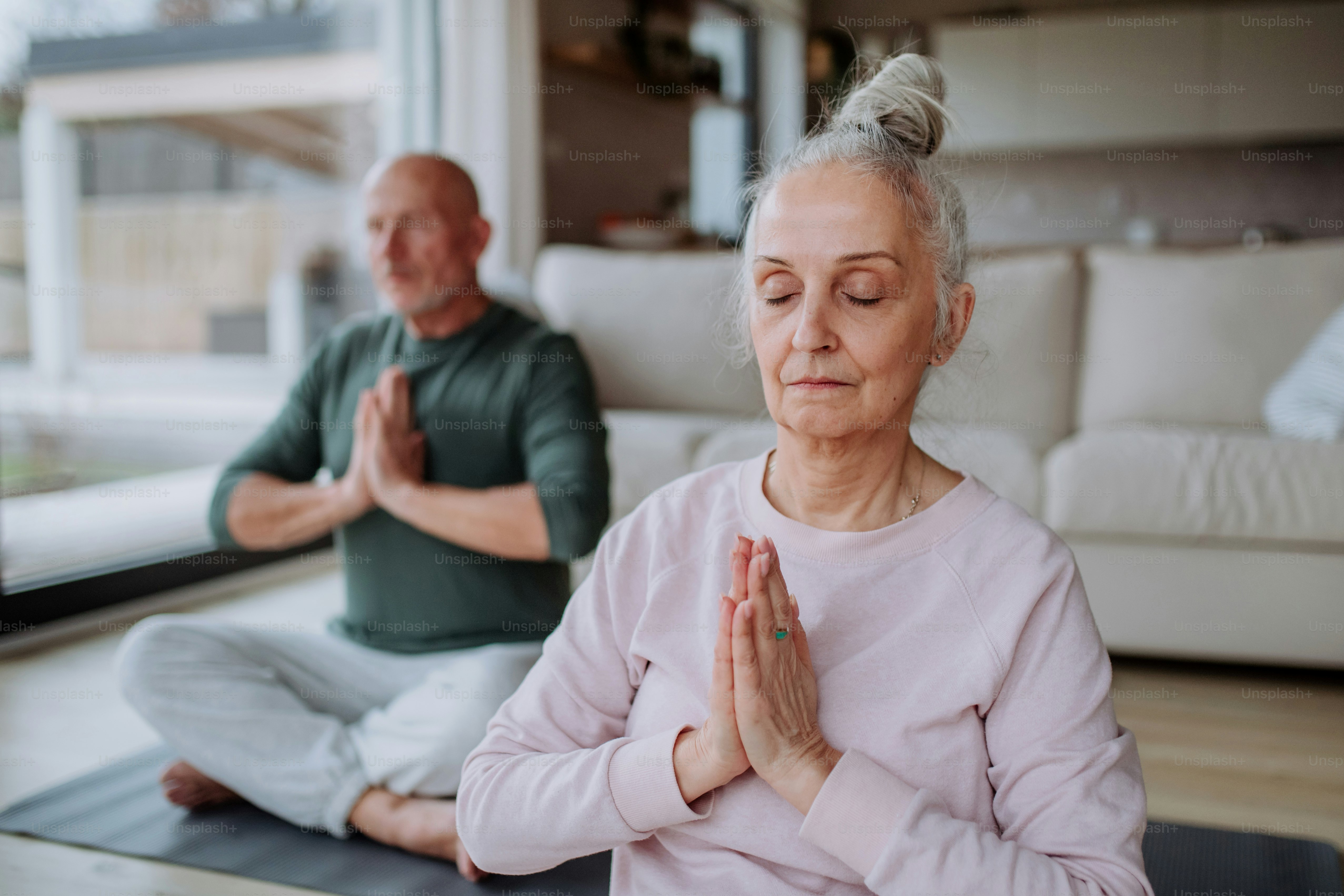 A senior couple doing relaxation exercise together at home. photo ...