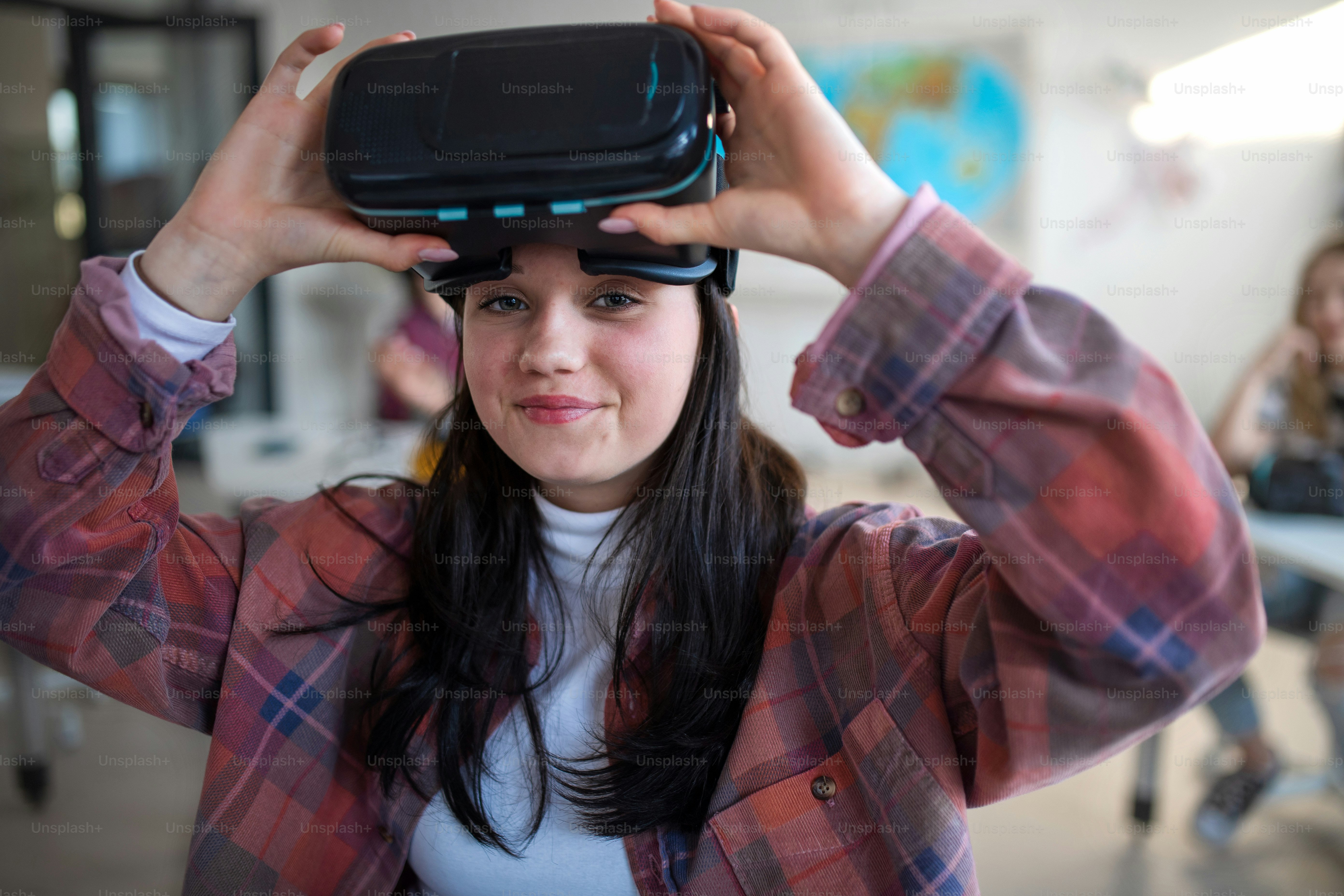 A happy student wearing virtual reality goggles at school in computer ...