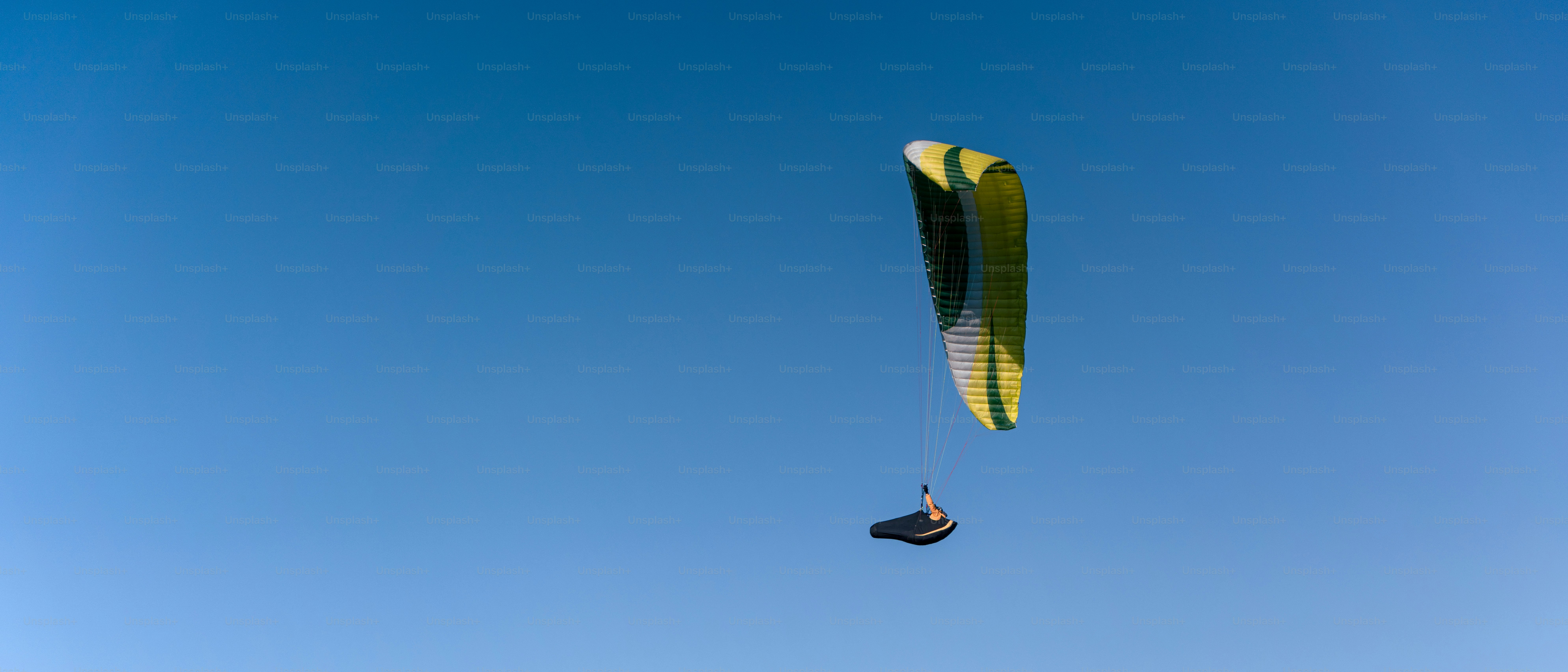 A paraglider in the blue sky. The sportsman flying on a paraglider. photo – Parachute Image on ...