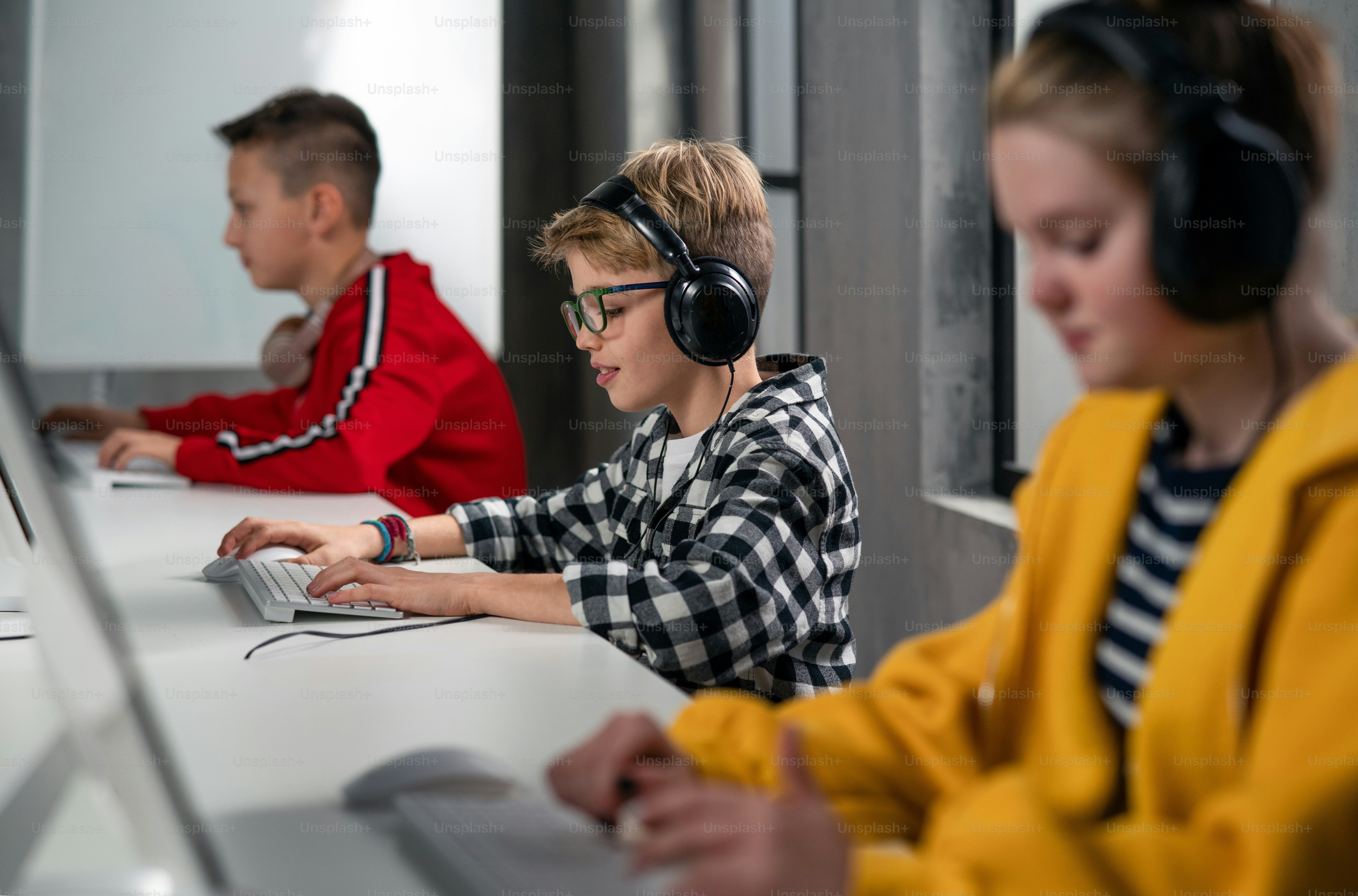 School kids using computer in a classroom at school photo – Sitting ...