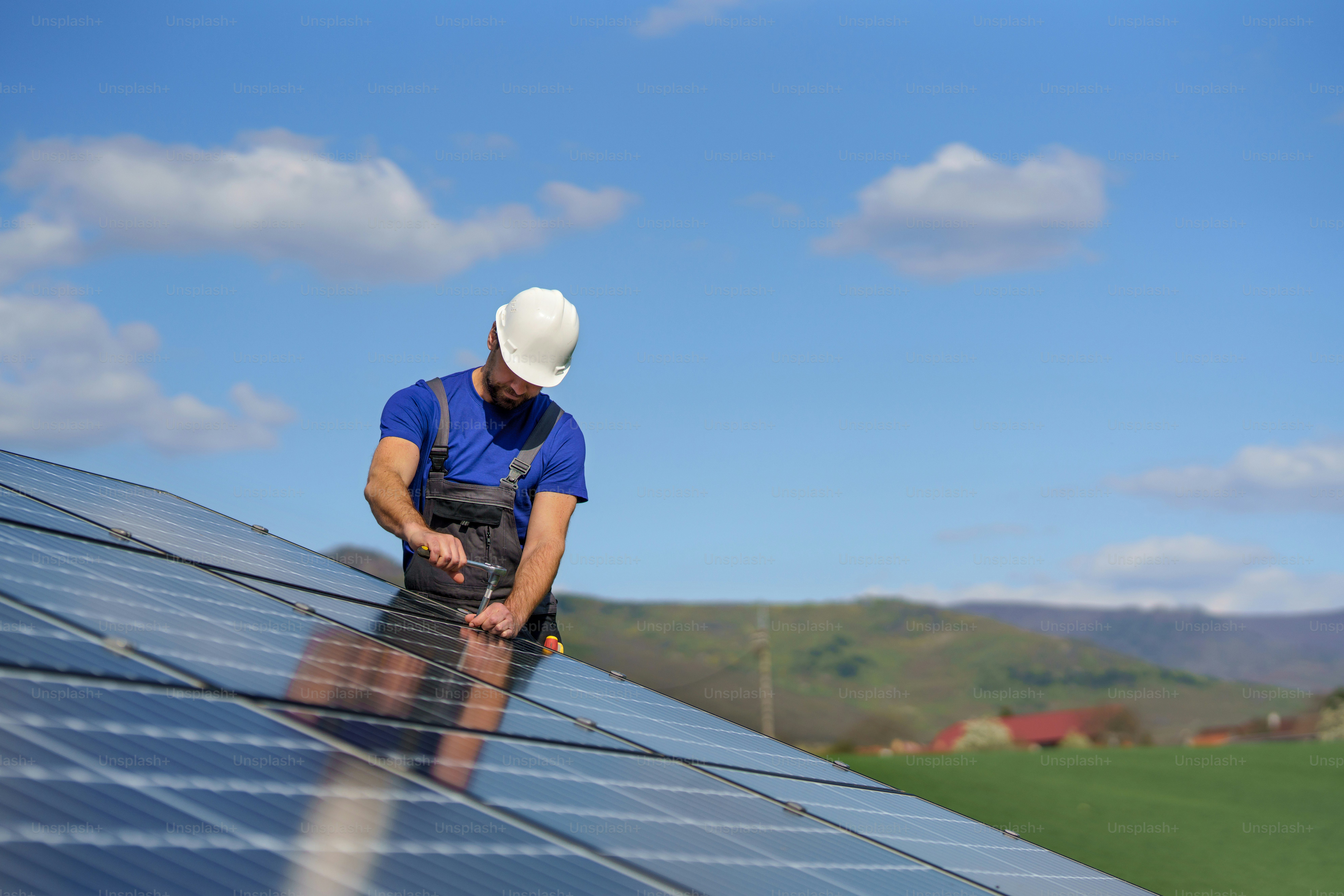A man worker installing solar photovoltaic panels on roof, alternative ...