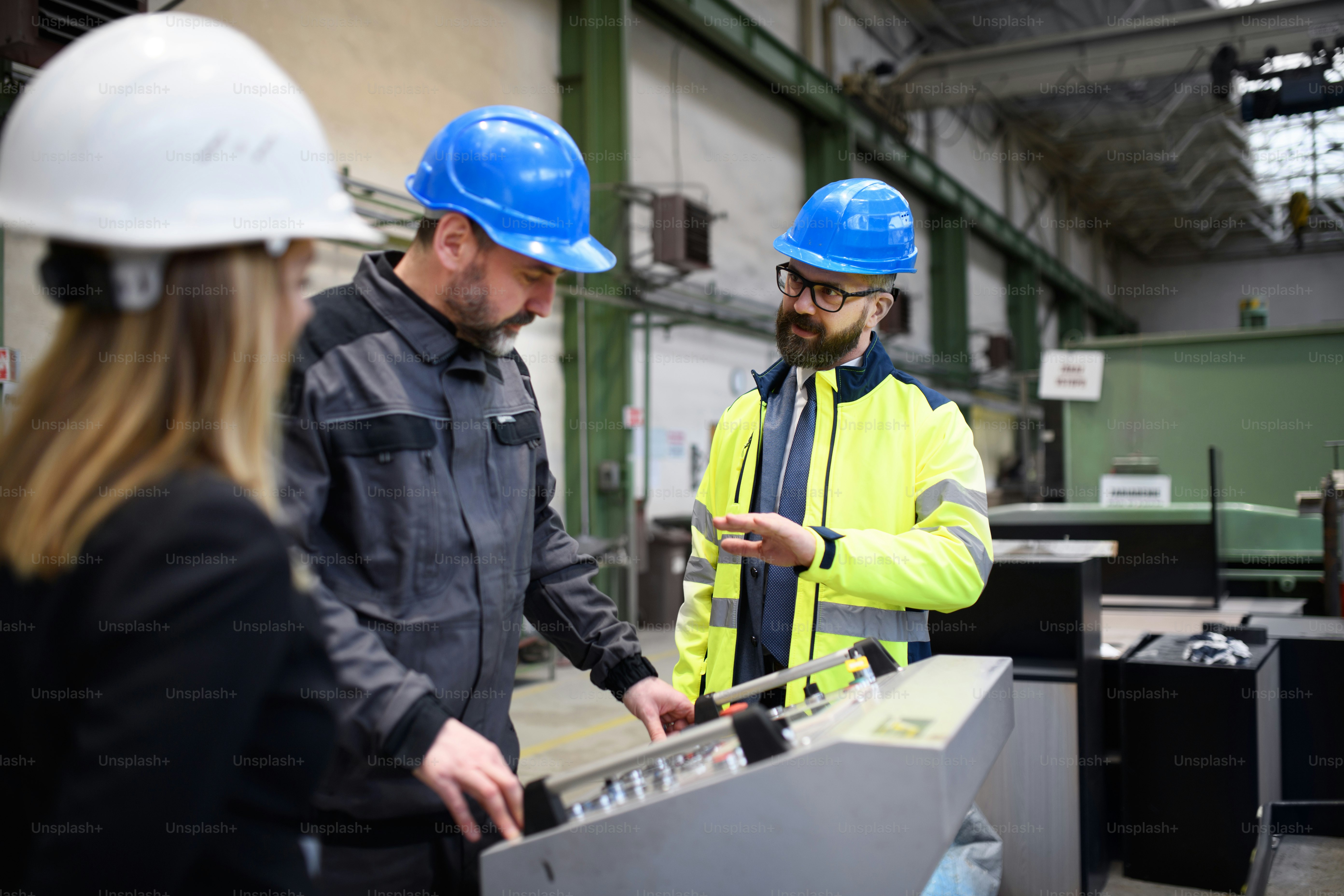 Manager supervisors and a industrial worker in uniform doing control in ...