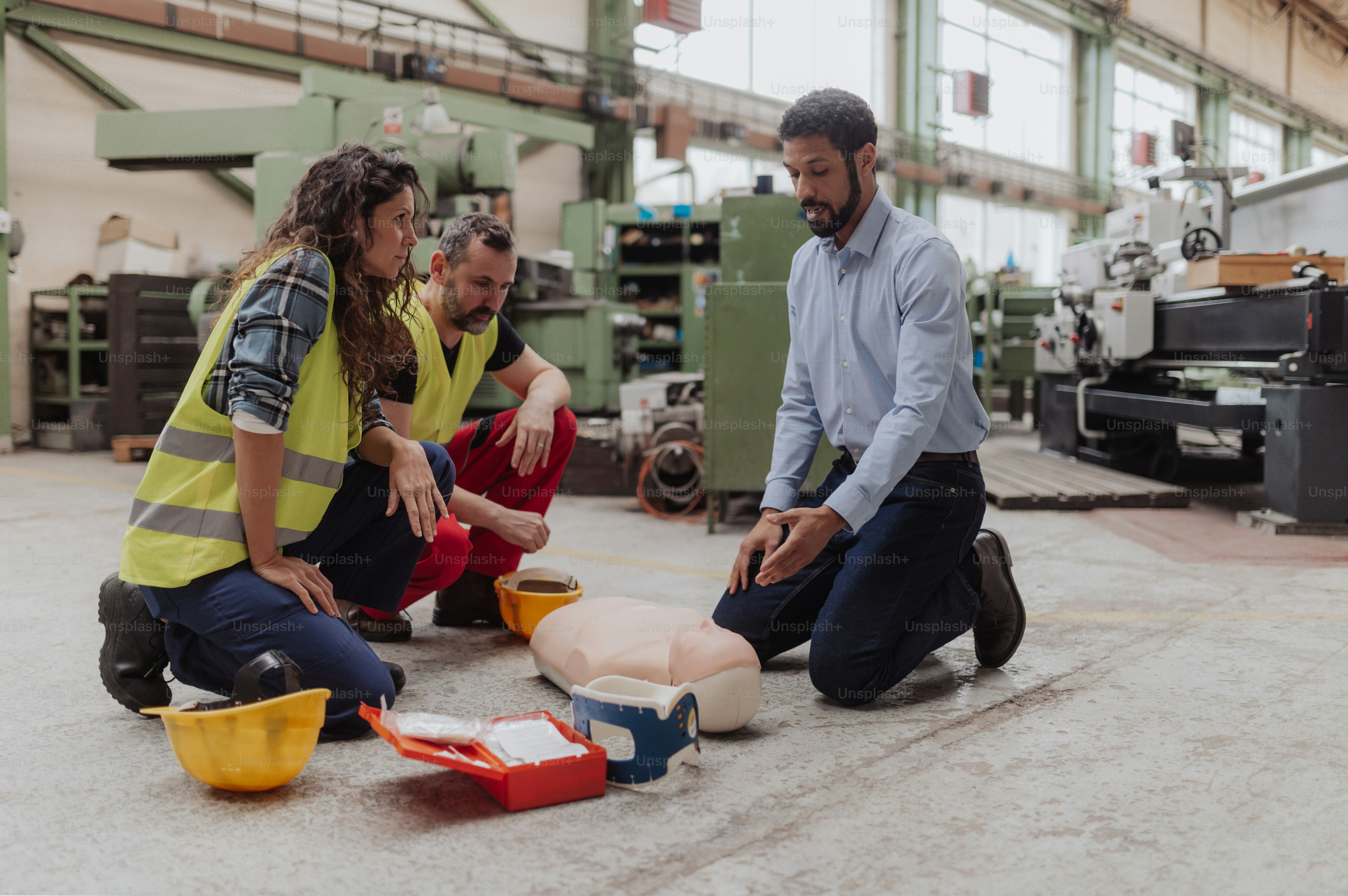 A male instructor showing first medical aid on doll during training ...