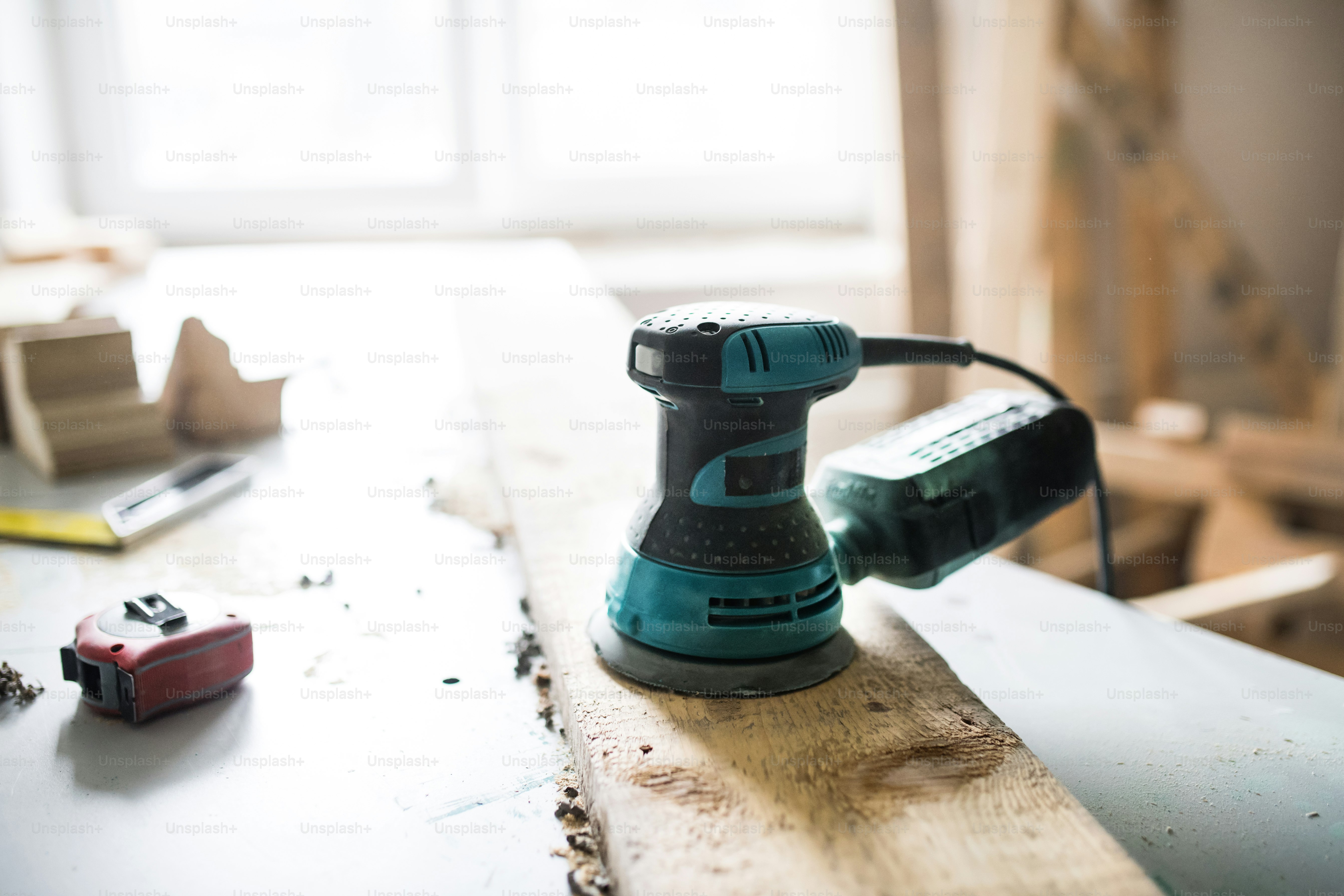 Angle grinder in carpenter workroom. Electric tool and tape measurer on ...