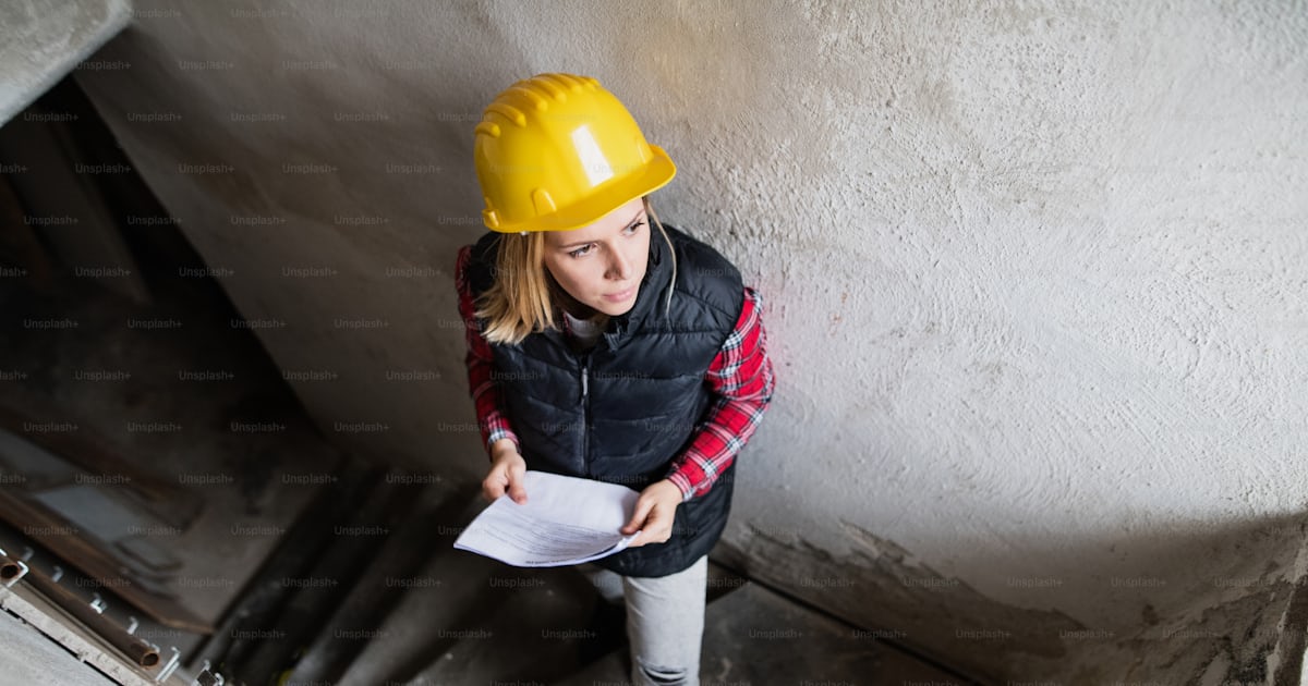 建設現場の女性作業員。青写真を持っている美しい若い女性。住宅建設。上面図。の写真 衣類 Unsplashの写真