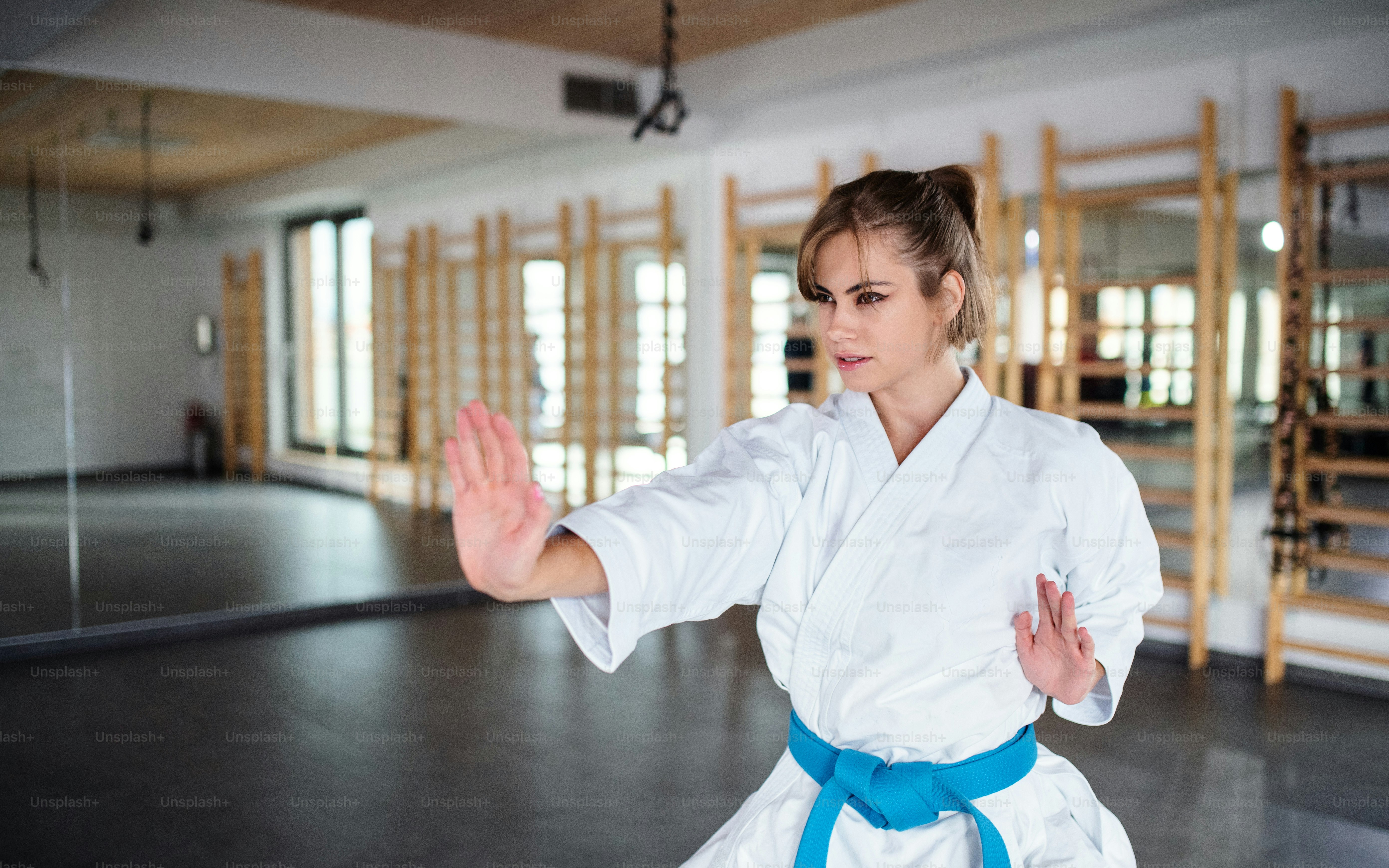 A group of young women practising karate indoors in gym. photo ...
