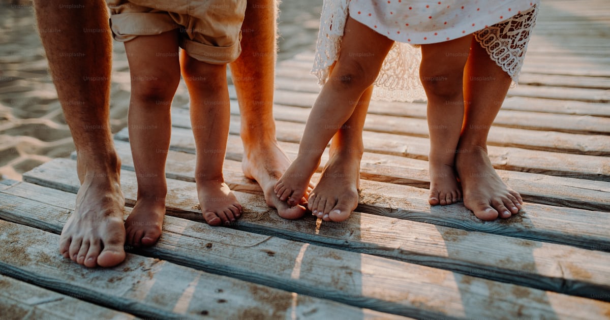 Jambes Et Pieds Dune Famille Debout Sur La Plage Pendant Les Vacances