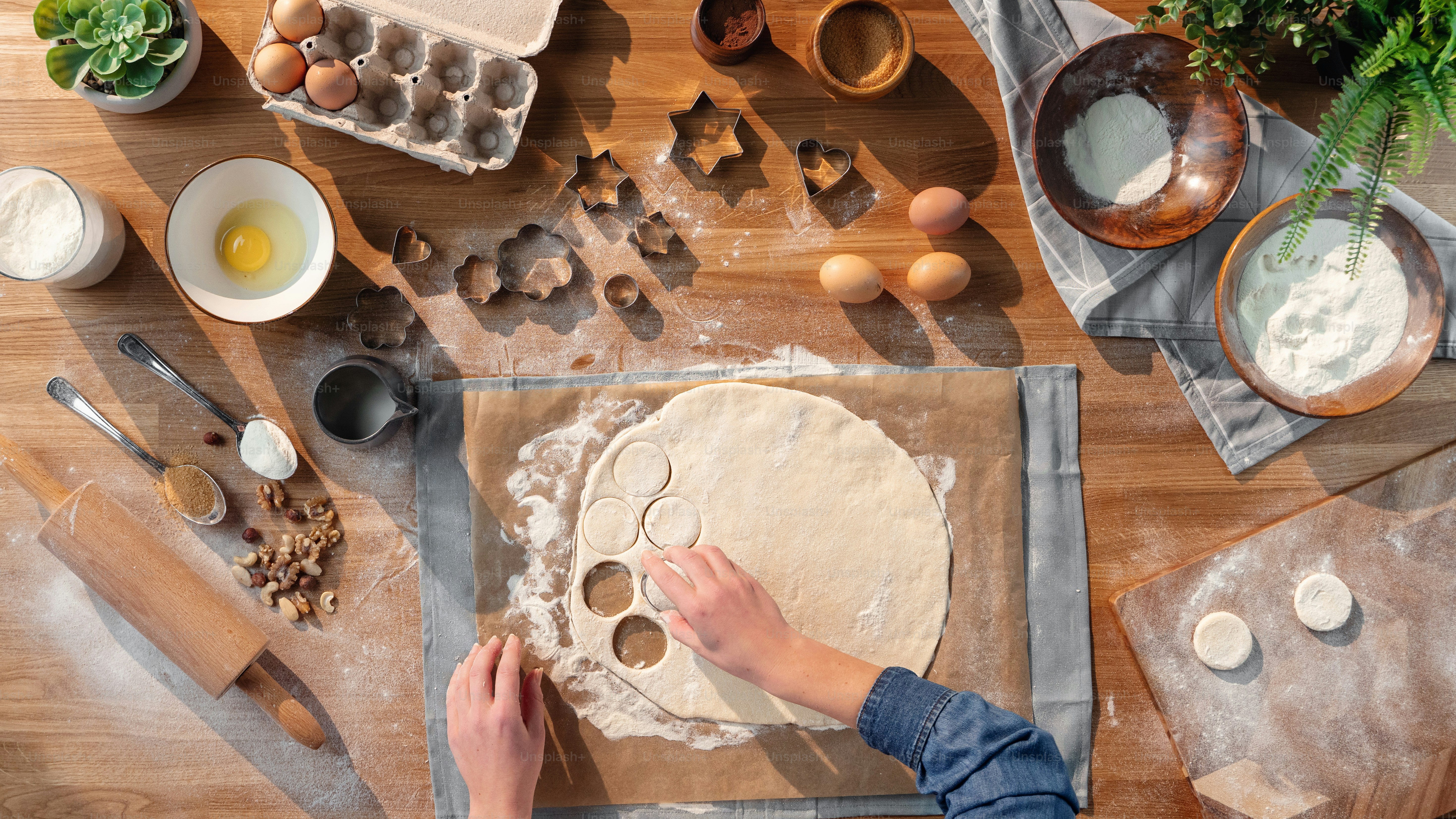 A top view of unrecognizable woman baking biscuits, desktop concept ...
