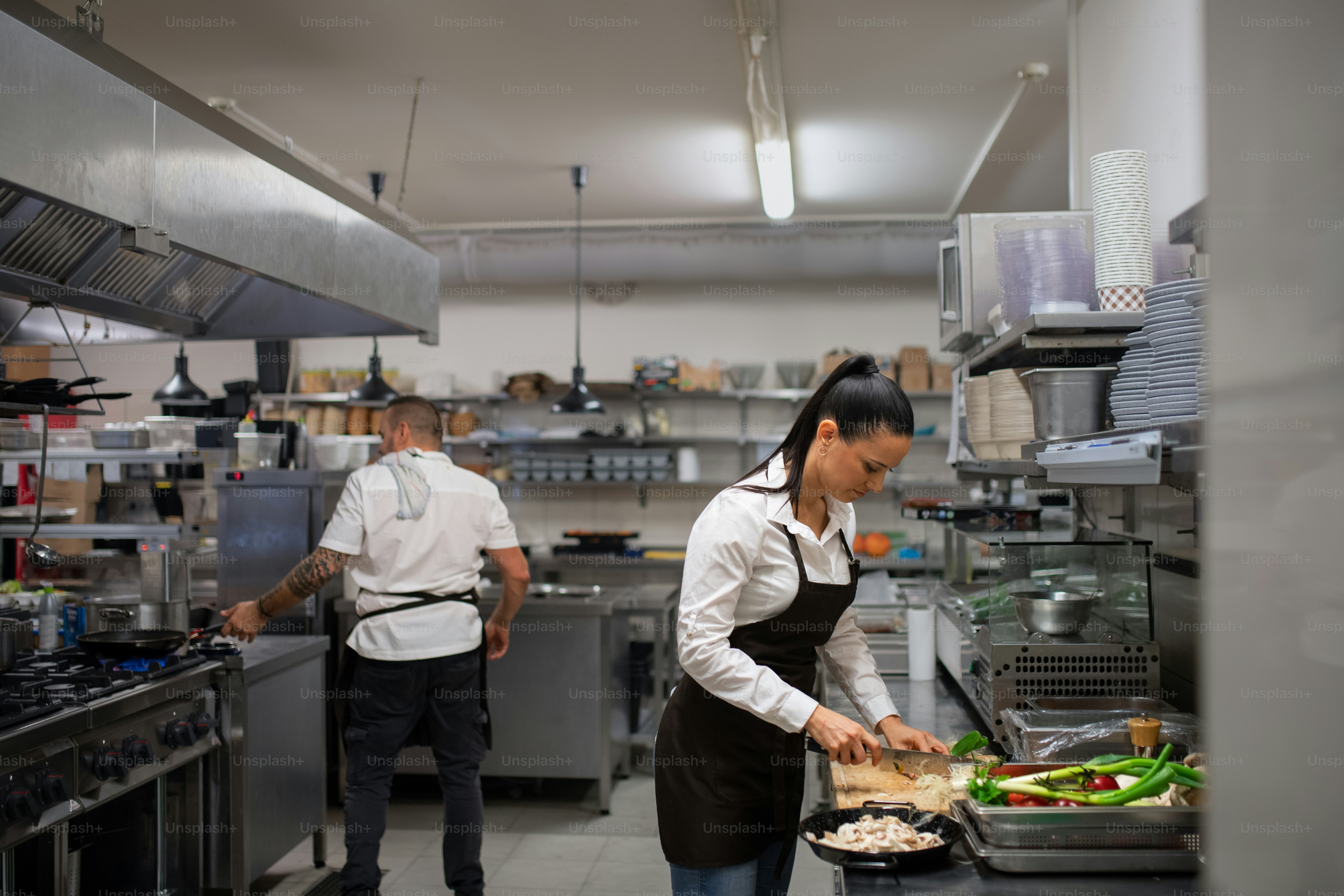 Una chef profesional cortando verduras en el interior de la cocina de un restaurante. foto ...