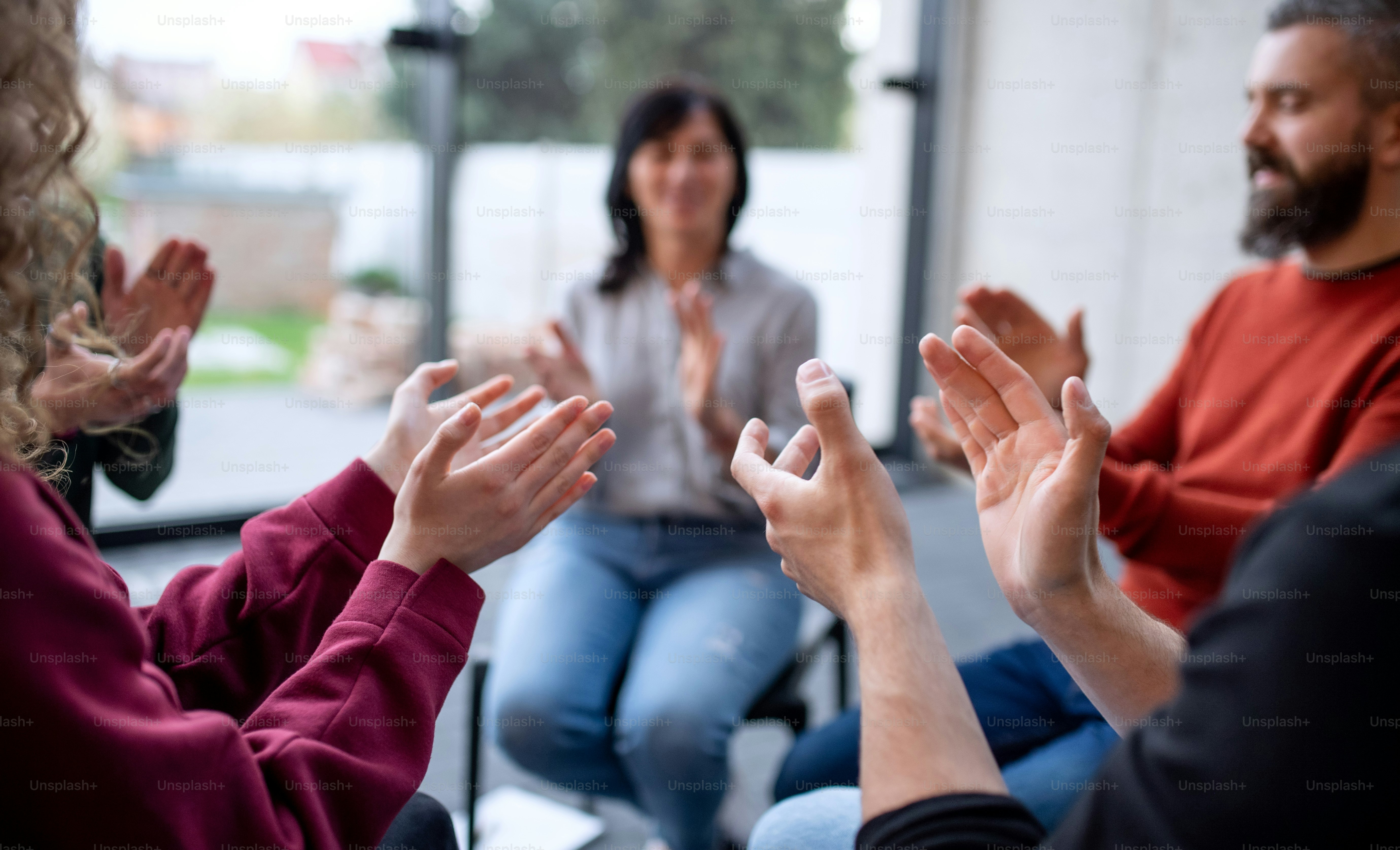 Men and women sitting in a circle during group therapy, clapping. photo ...