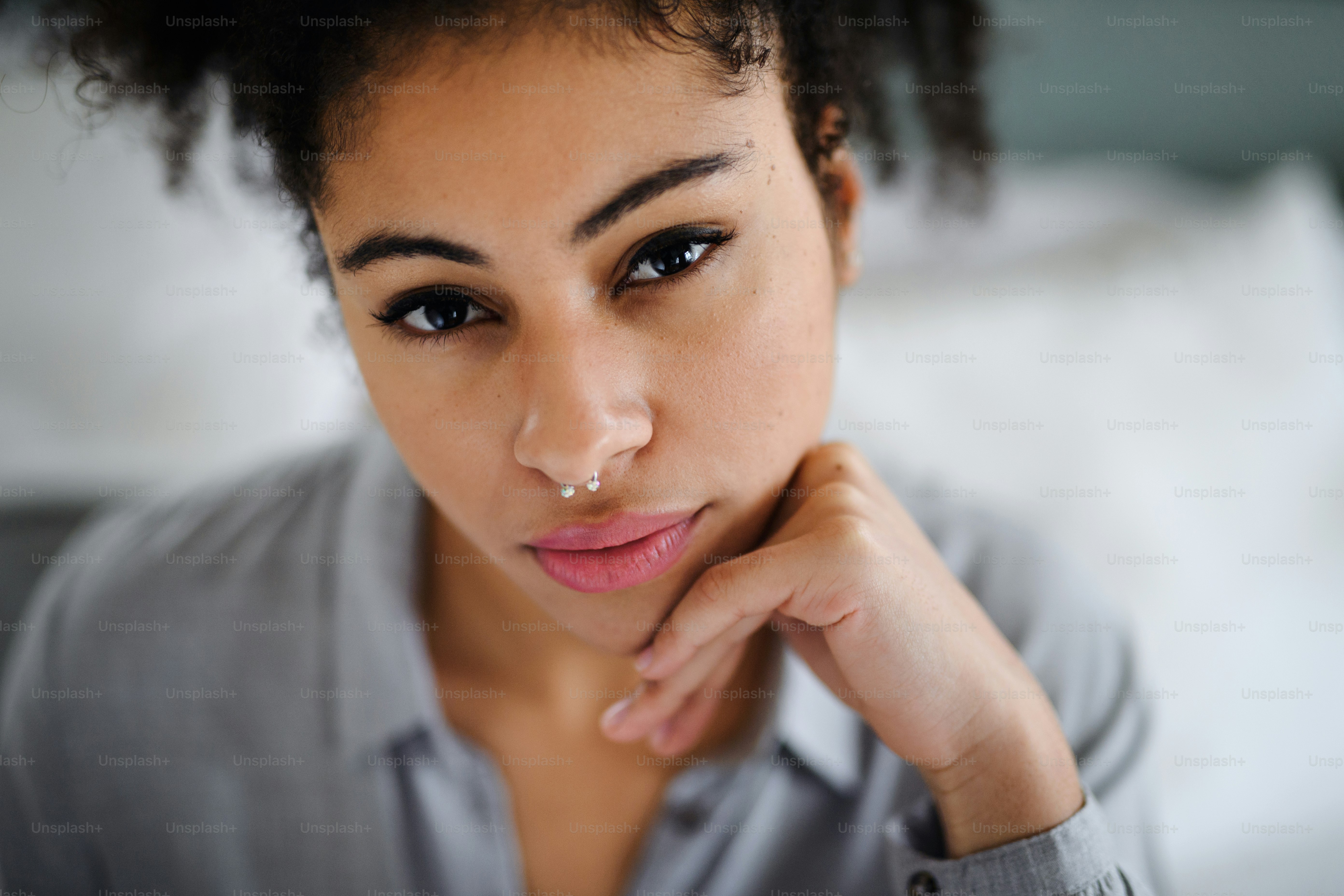 Close-up front view portrait of beautiful young woman indoors, looking ...